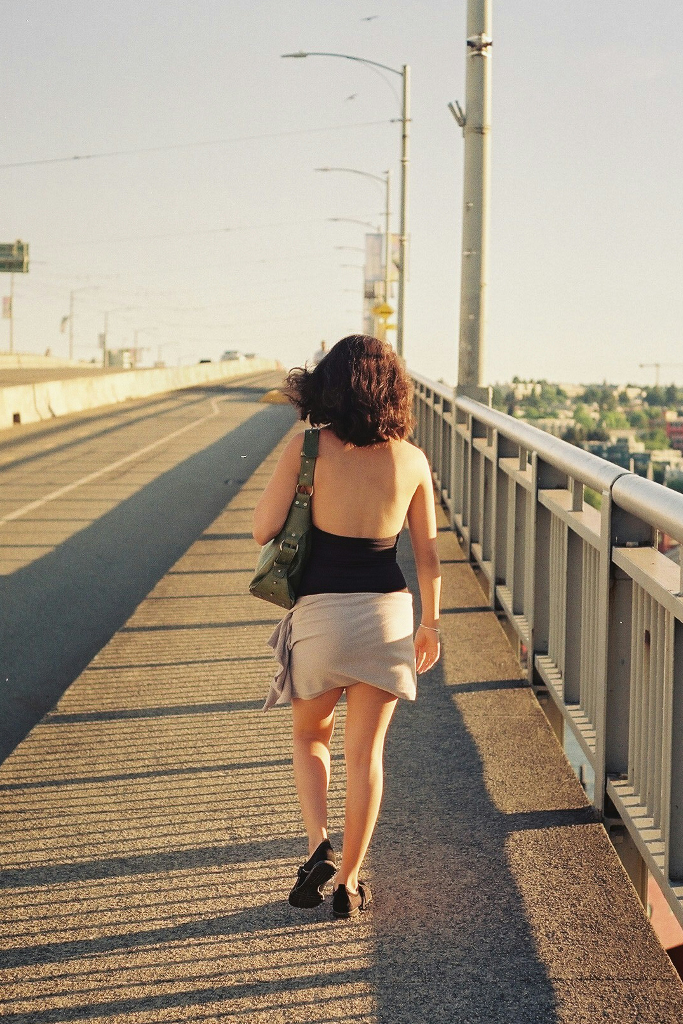 Stride on the Riverside Bridge: A Woman Walking Toward Wide Horizons