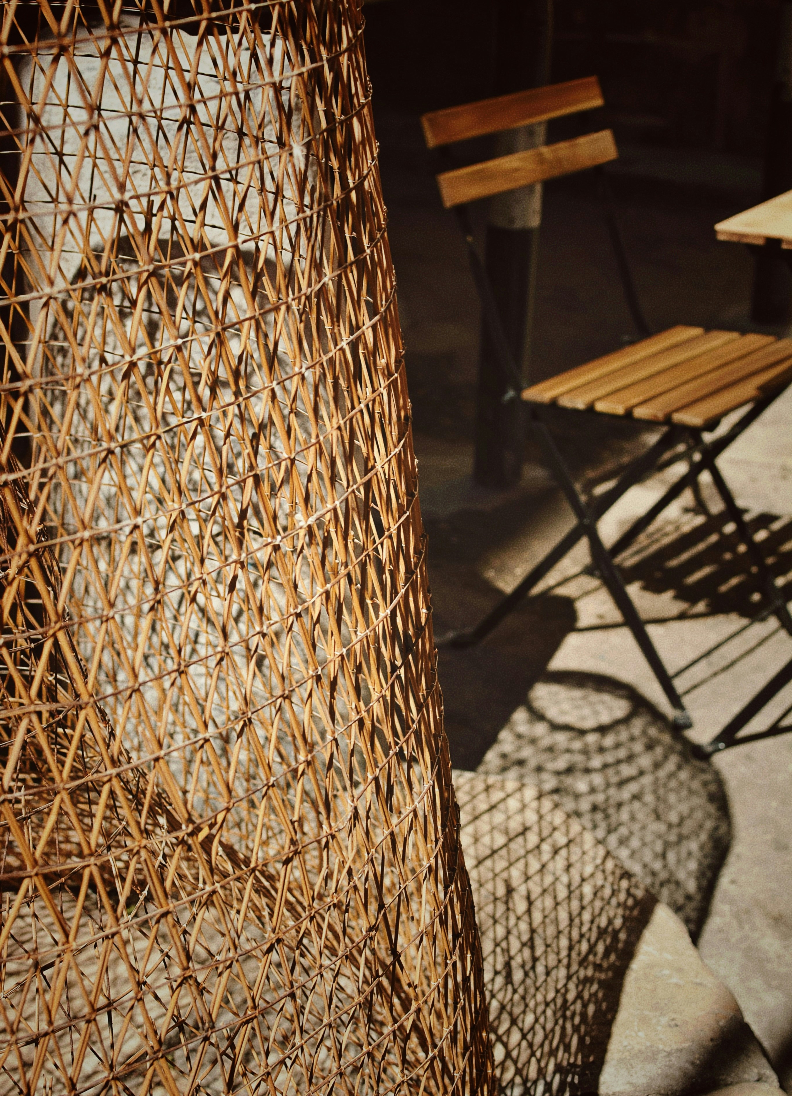 Shadows and Weave: A Chair Leg of Sunlit Courtyard
