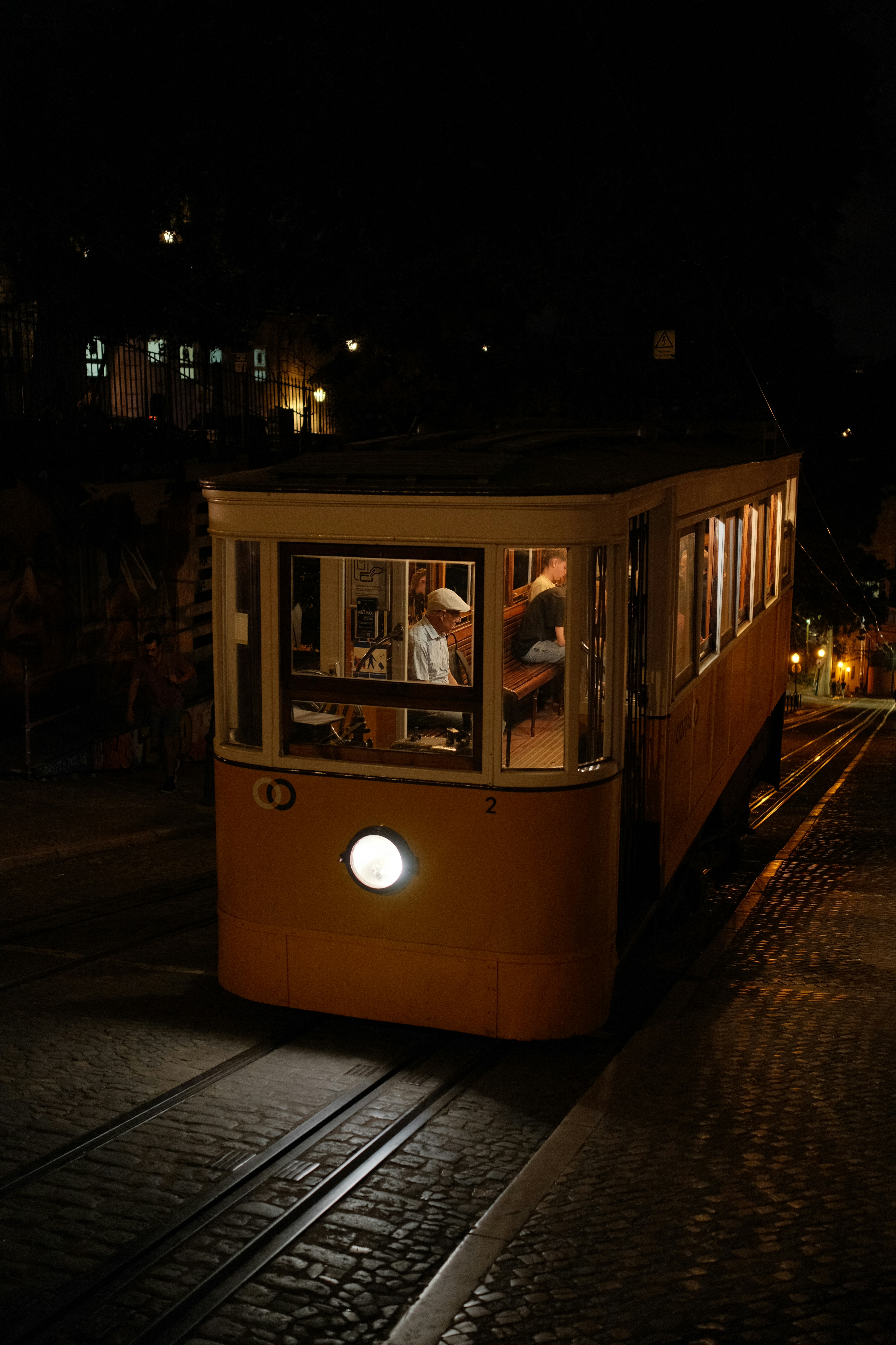 Night Tram in Golden Hue: A Quiet Ride Through Cobblestones