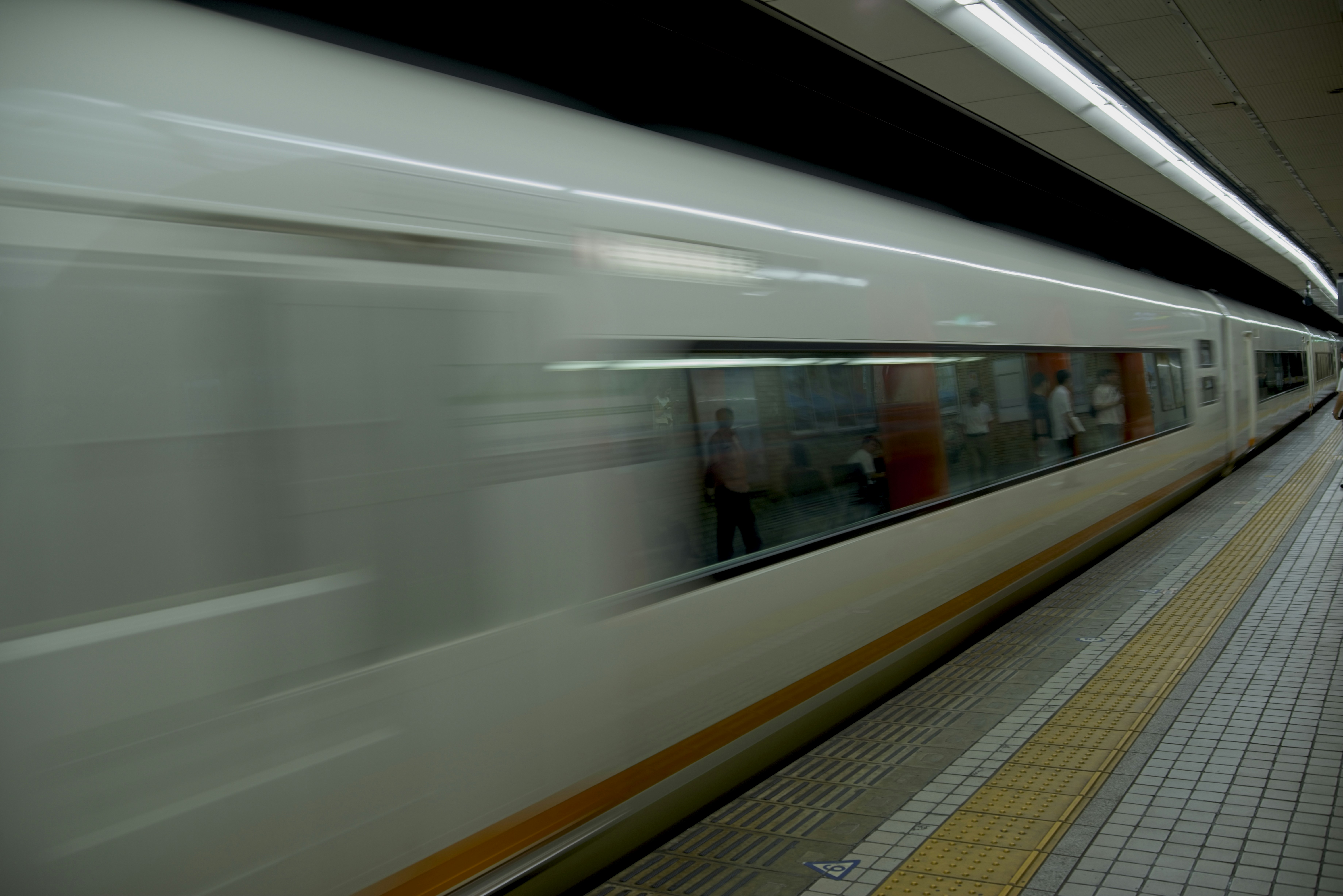 Blurred Arrival: A Subway Speeds Past in a Quiet Station