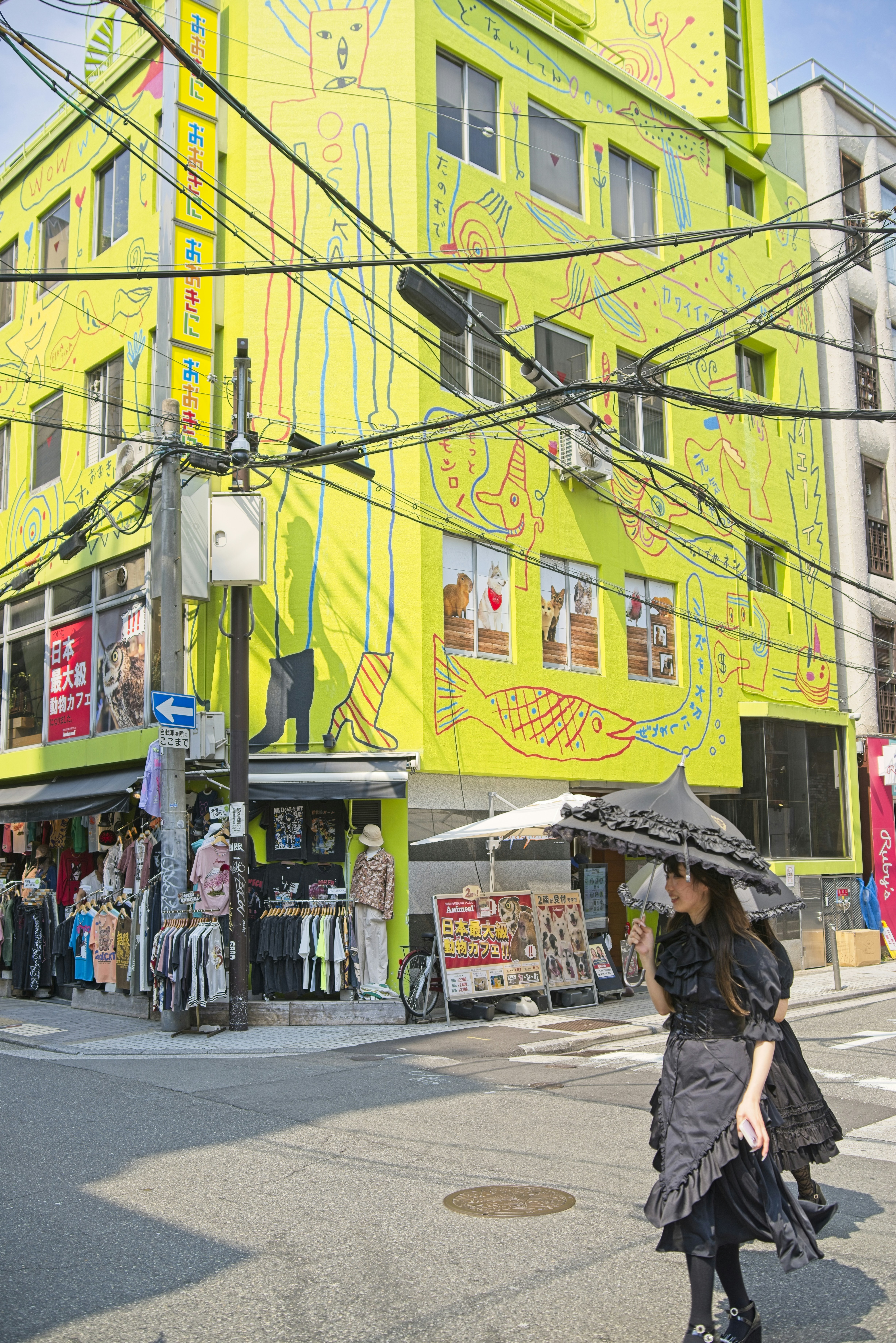 Yellow muraled building and stylish passerby on a sunny street