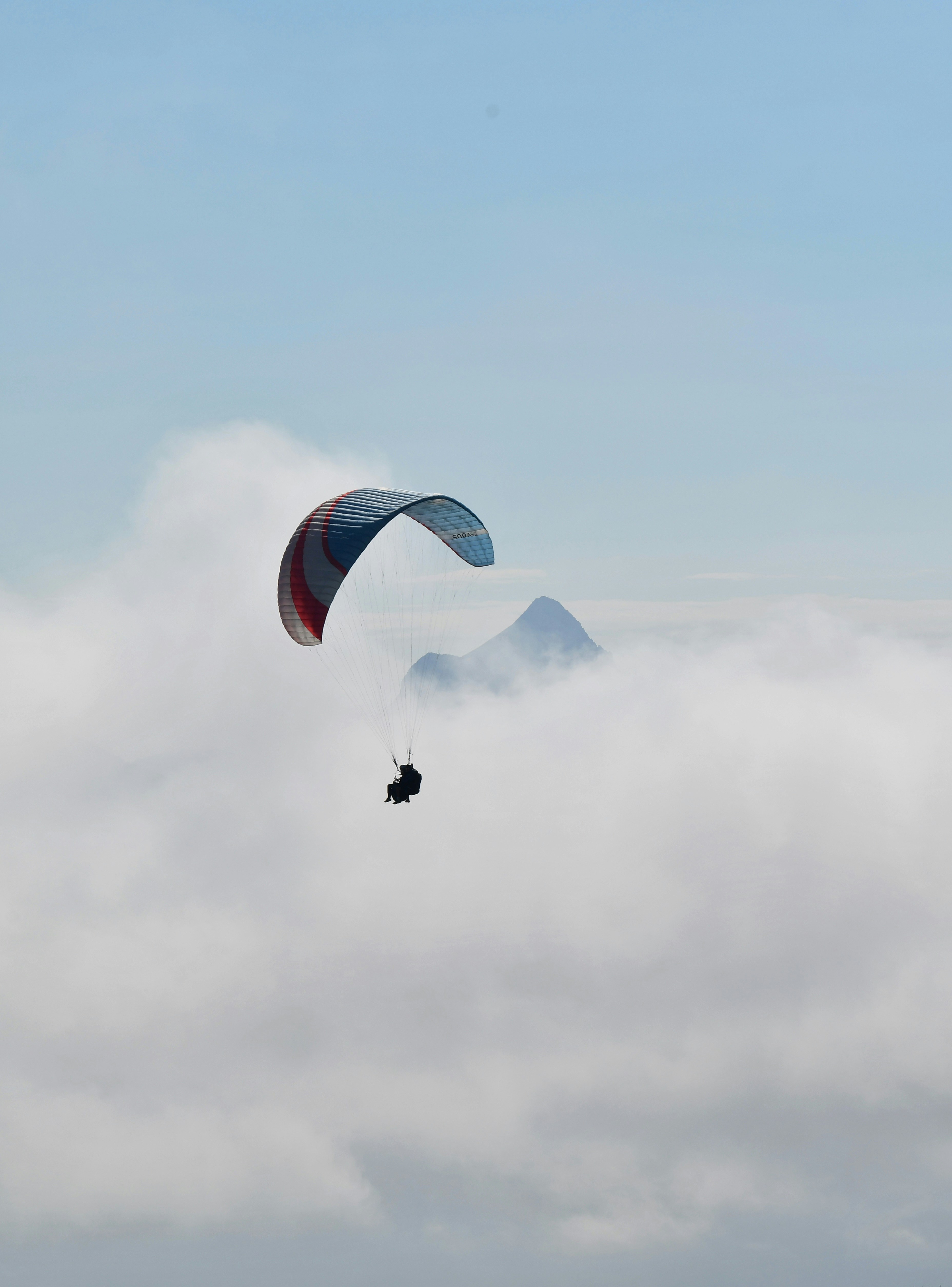 Midair Grace: Paraglider Above A Cresting Cloud Sea