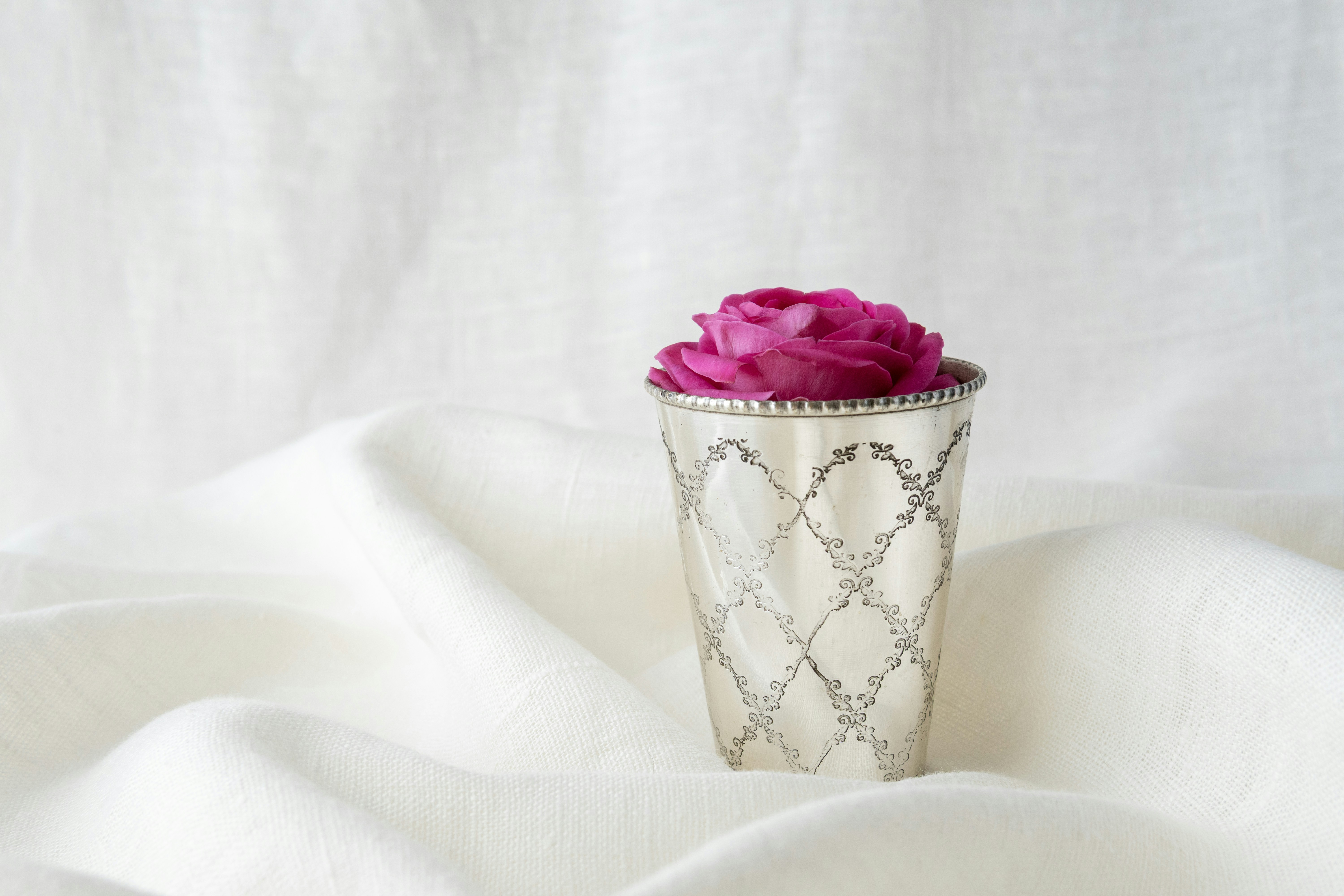 Pink Rose in Silver-Patterned Vase Anchored by Silk White Fabric