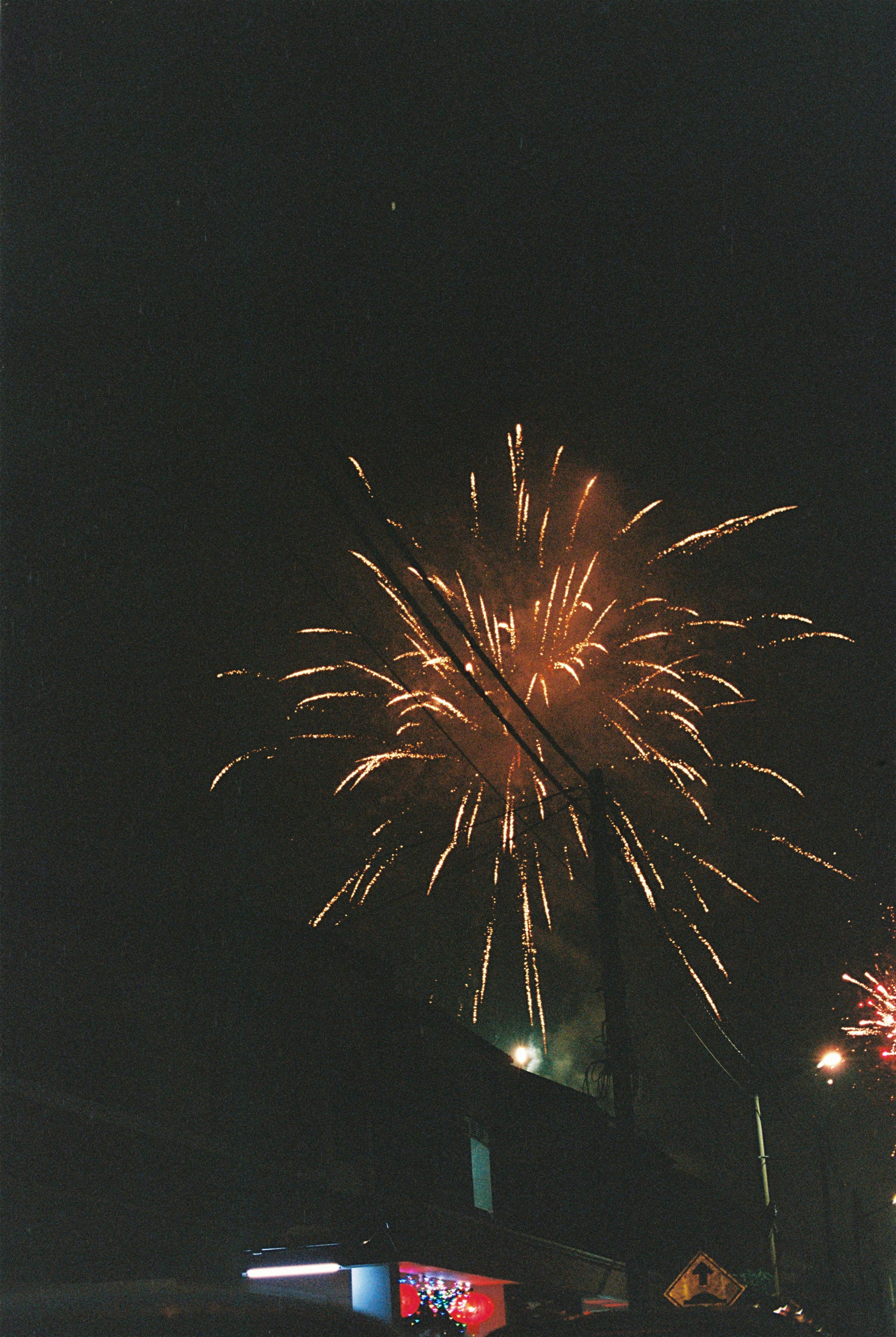 Night Market Fireworks Above a Quiet Street