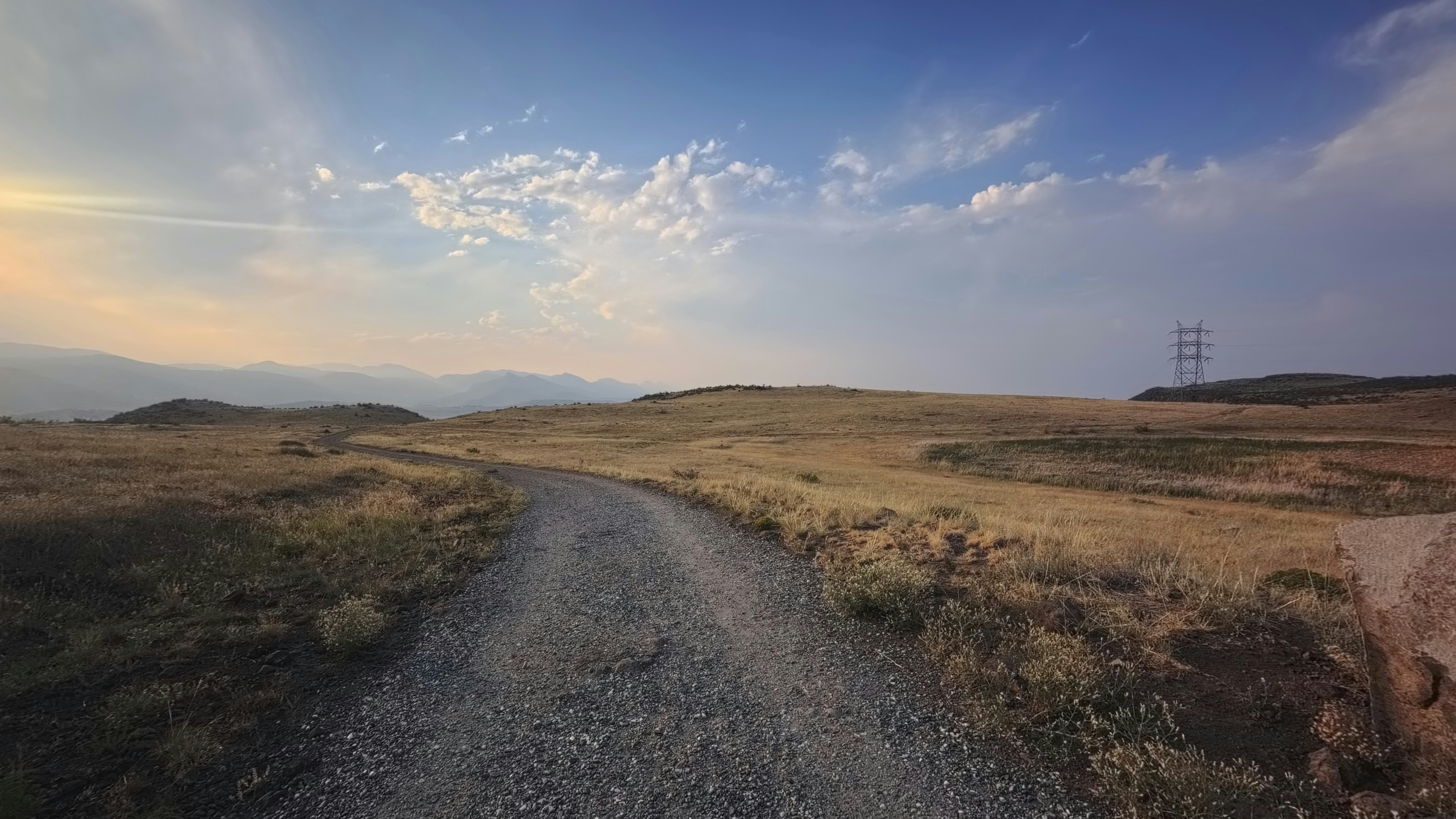 Dusty Path Toward the Distant Hills Under a Painted Sky