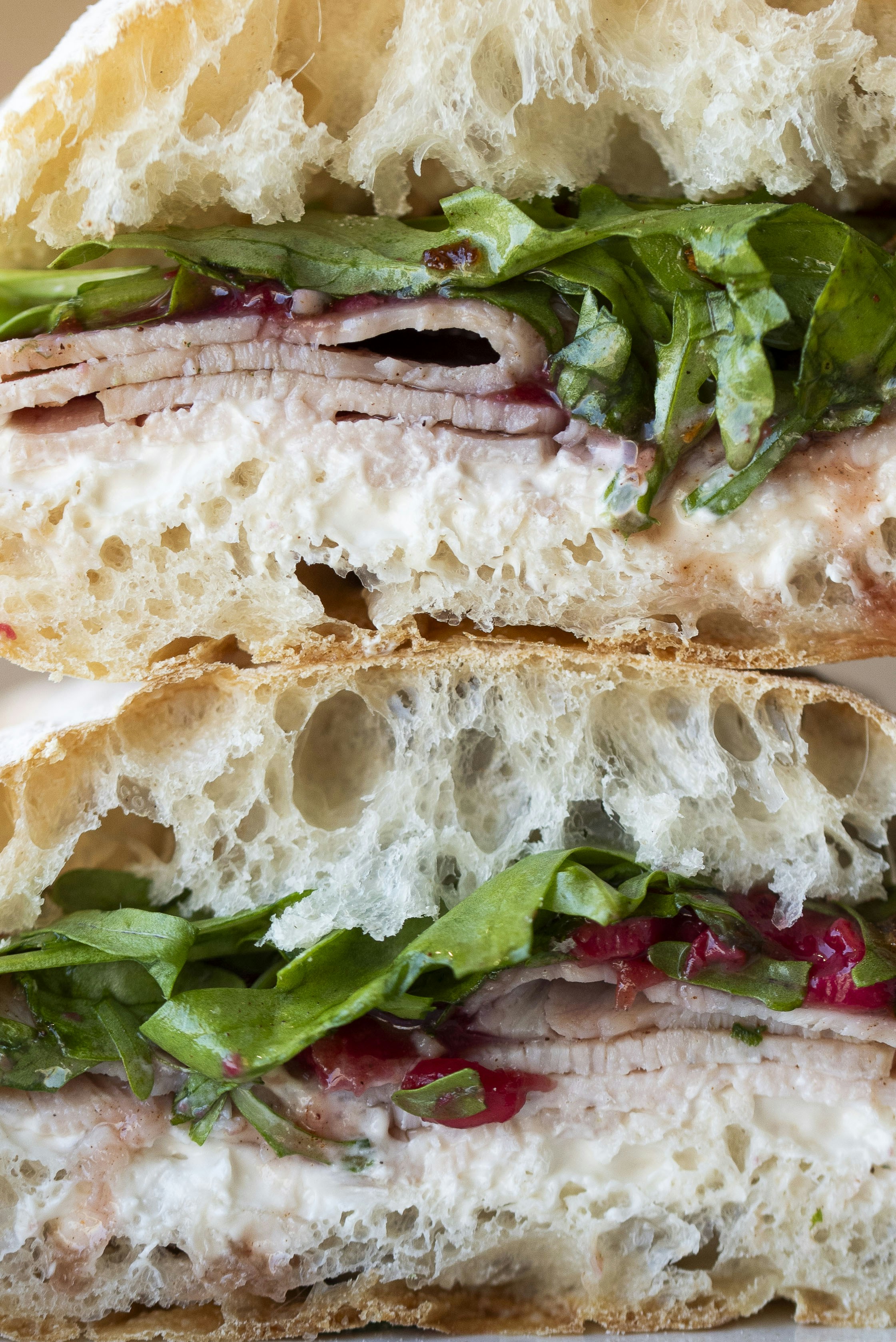 Heralded Bite: layered sandwich with fresh greens and creamy spread