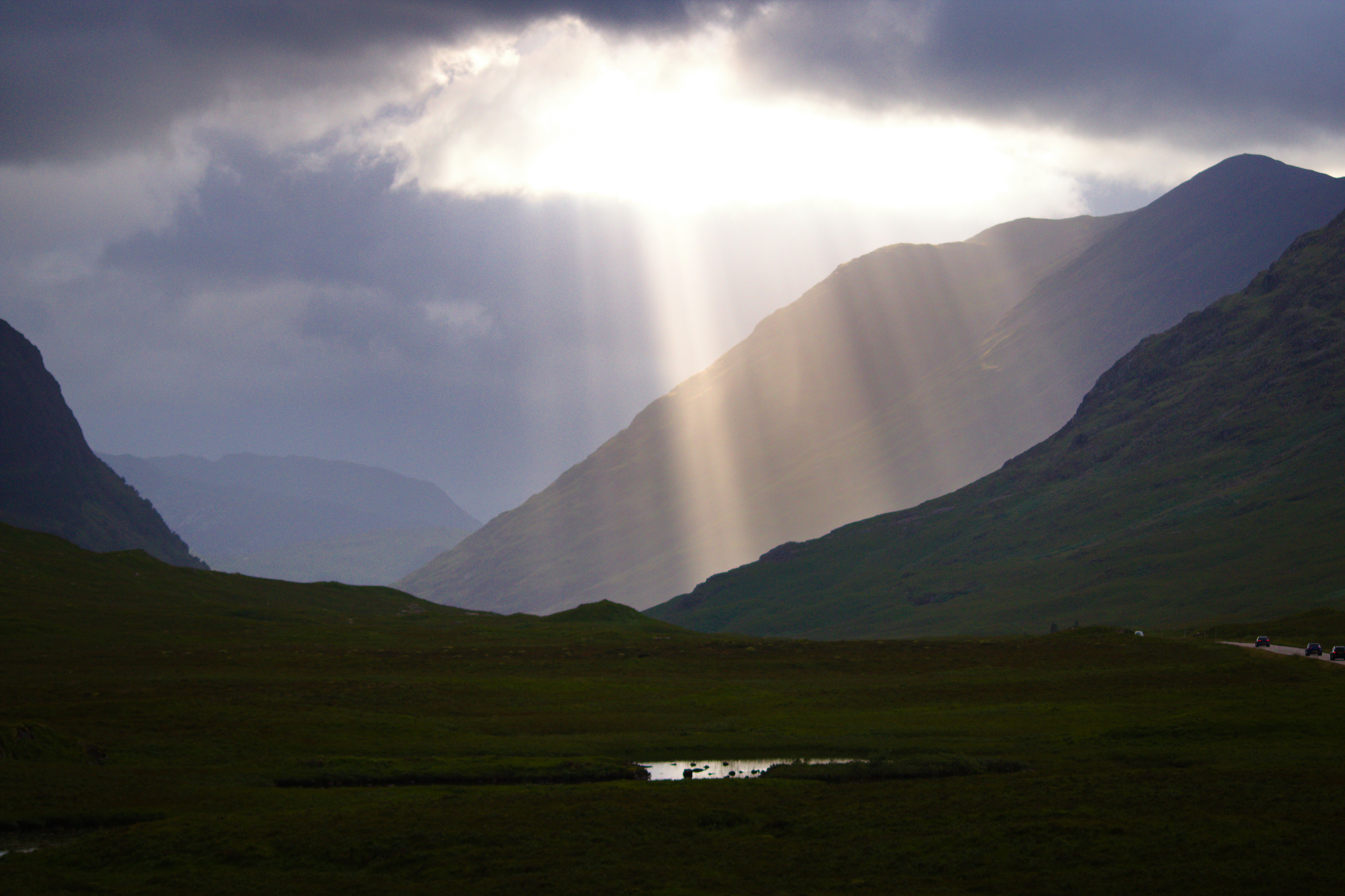 Sunbeams through a valley: dramatic light on distant slopes