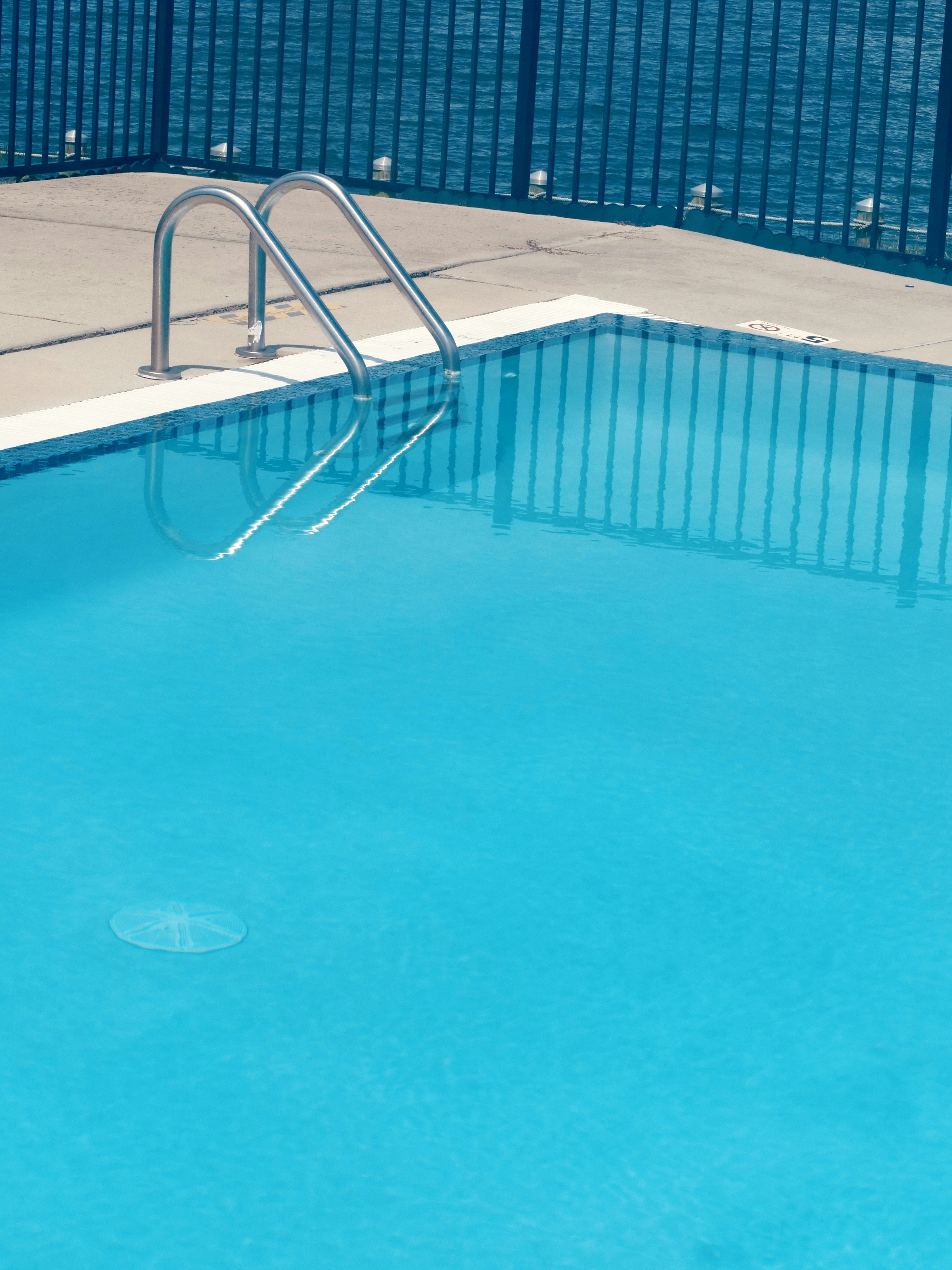 Teal Quiet: Edge of a Pool and Its Mirror