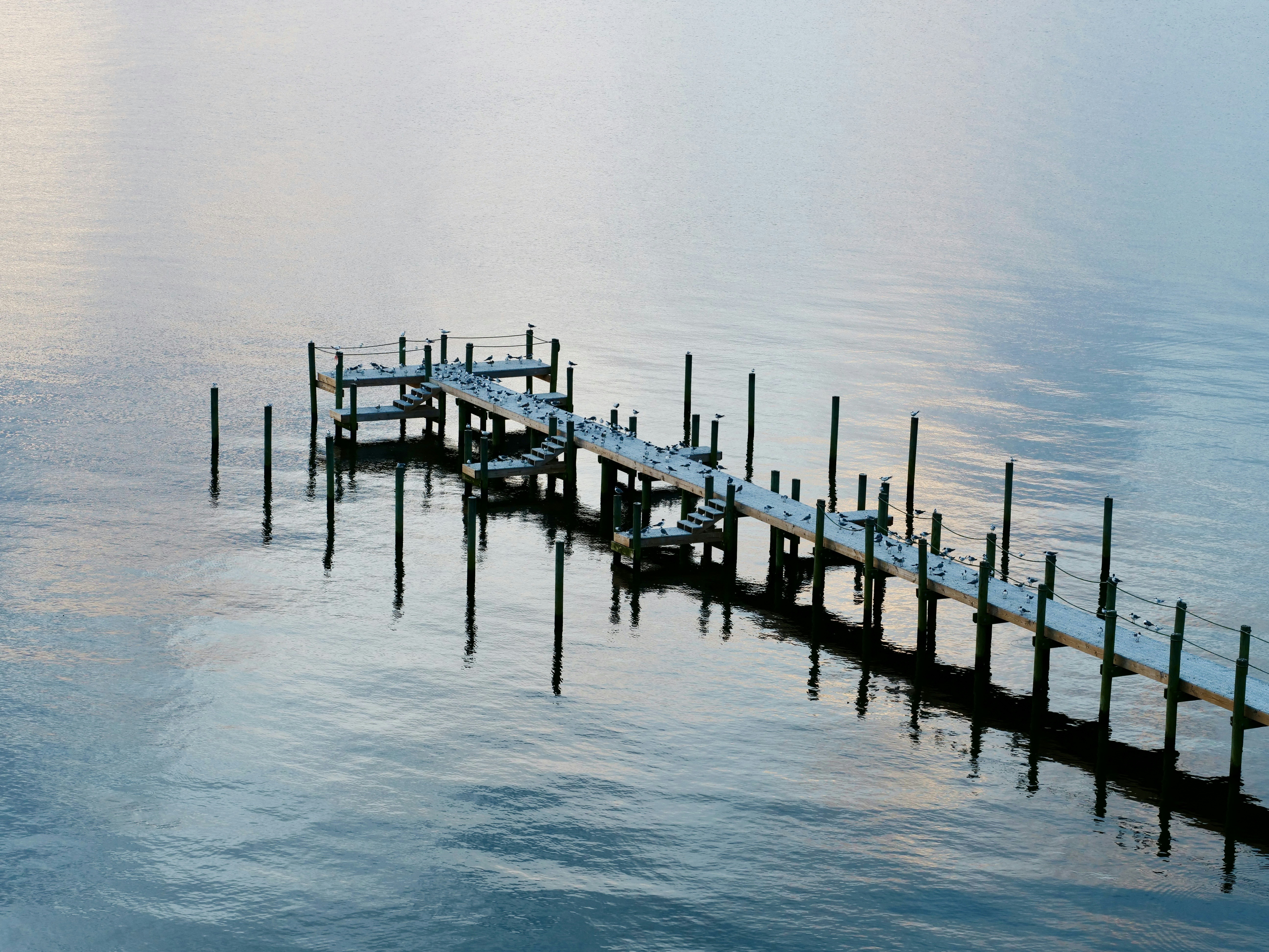 Quiet Pier Extends into a Glassy Lake at Dusk