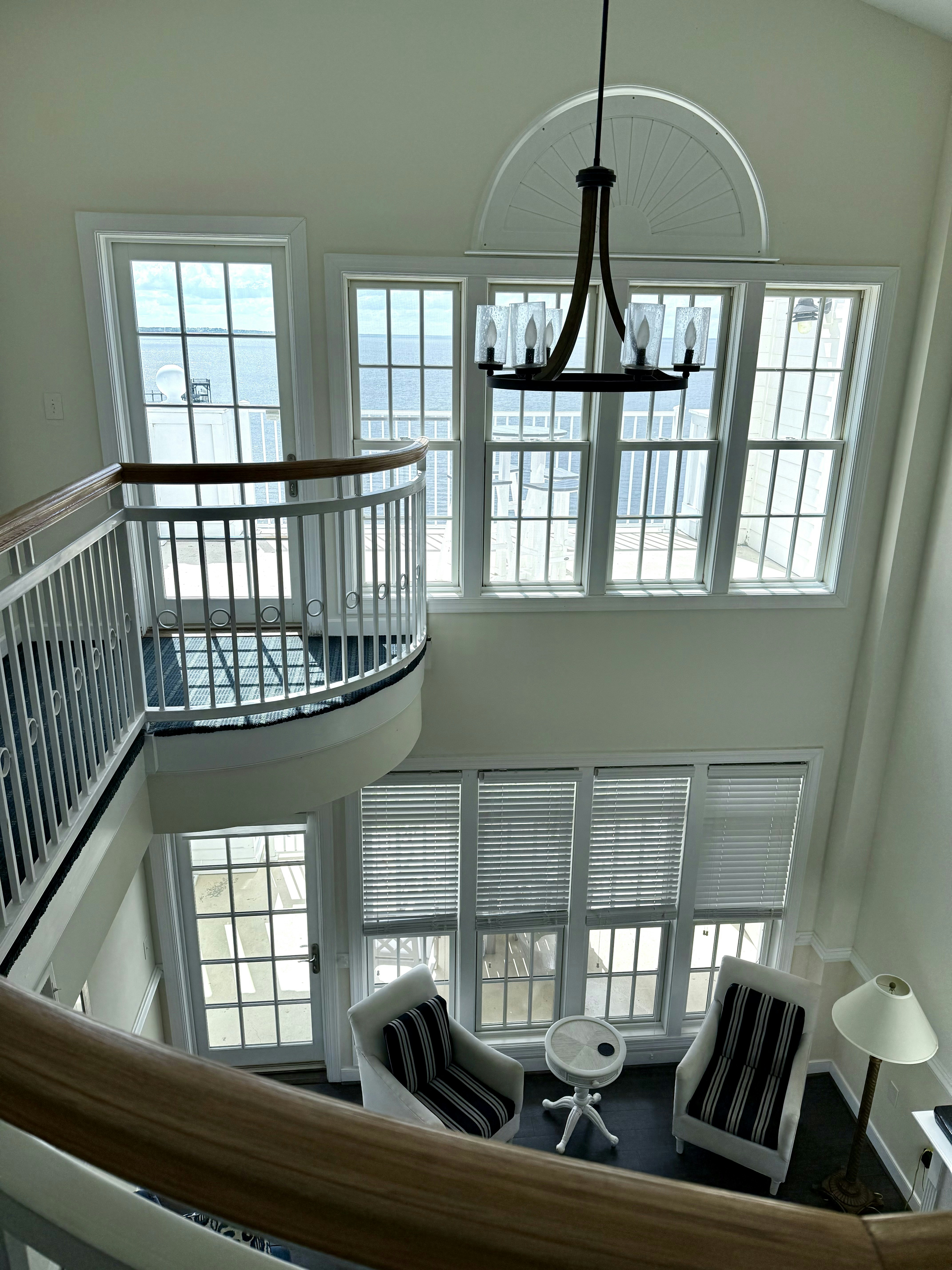 Sunlit two-story foyer: sweeping staircase and grand windows