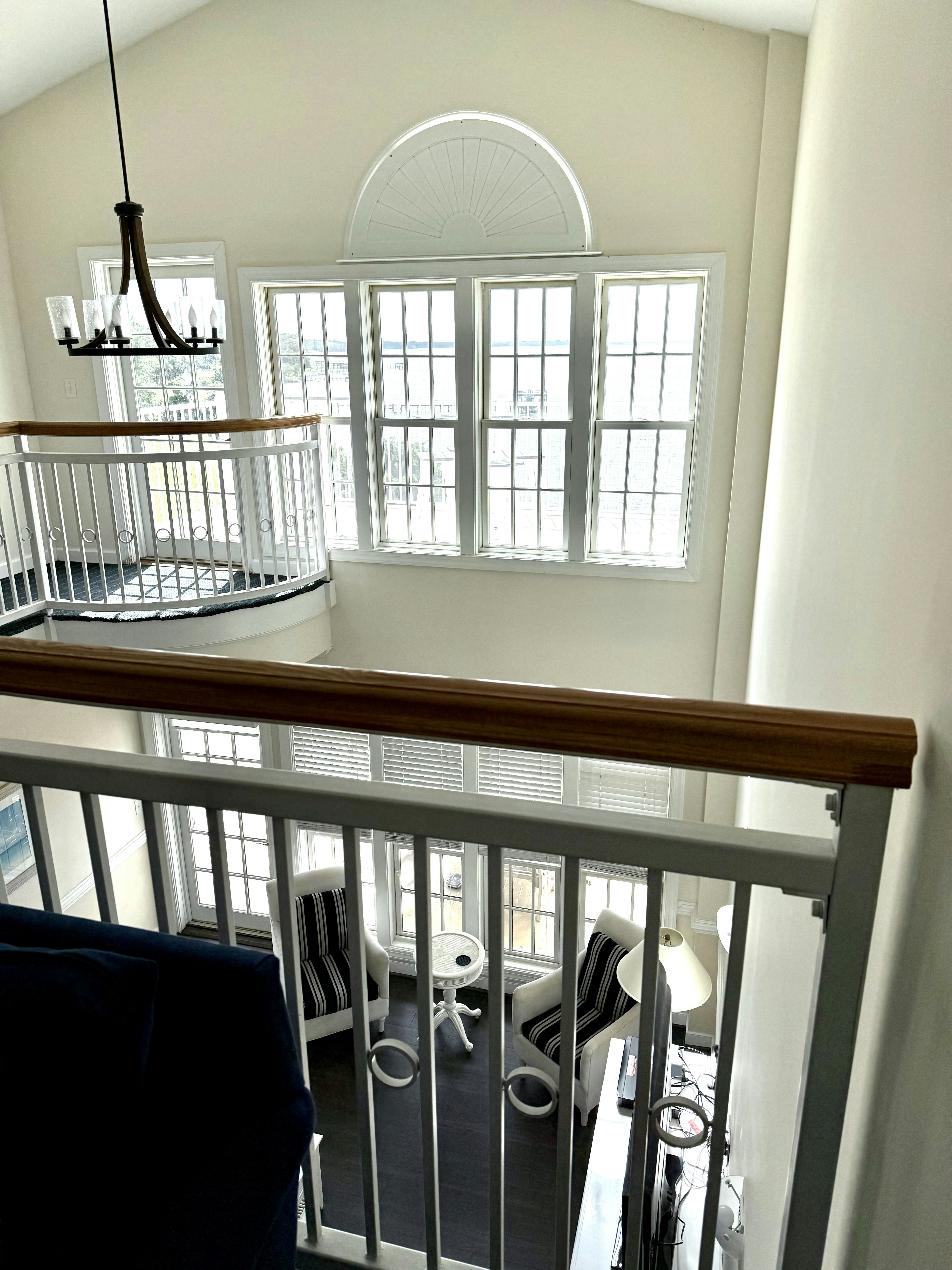Overlooked Balcony Gallery: Sunlit Staircase and Window Arc