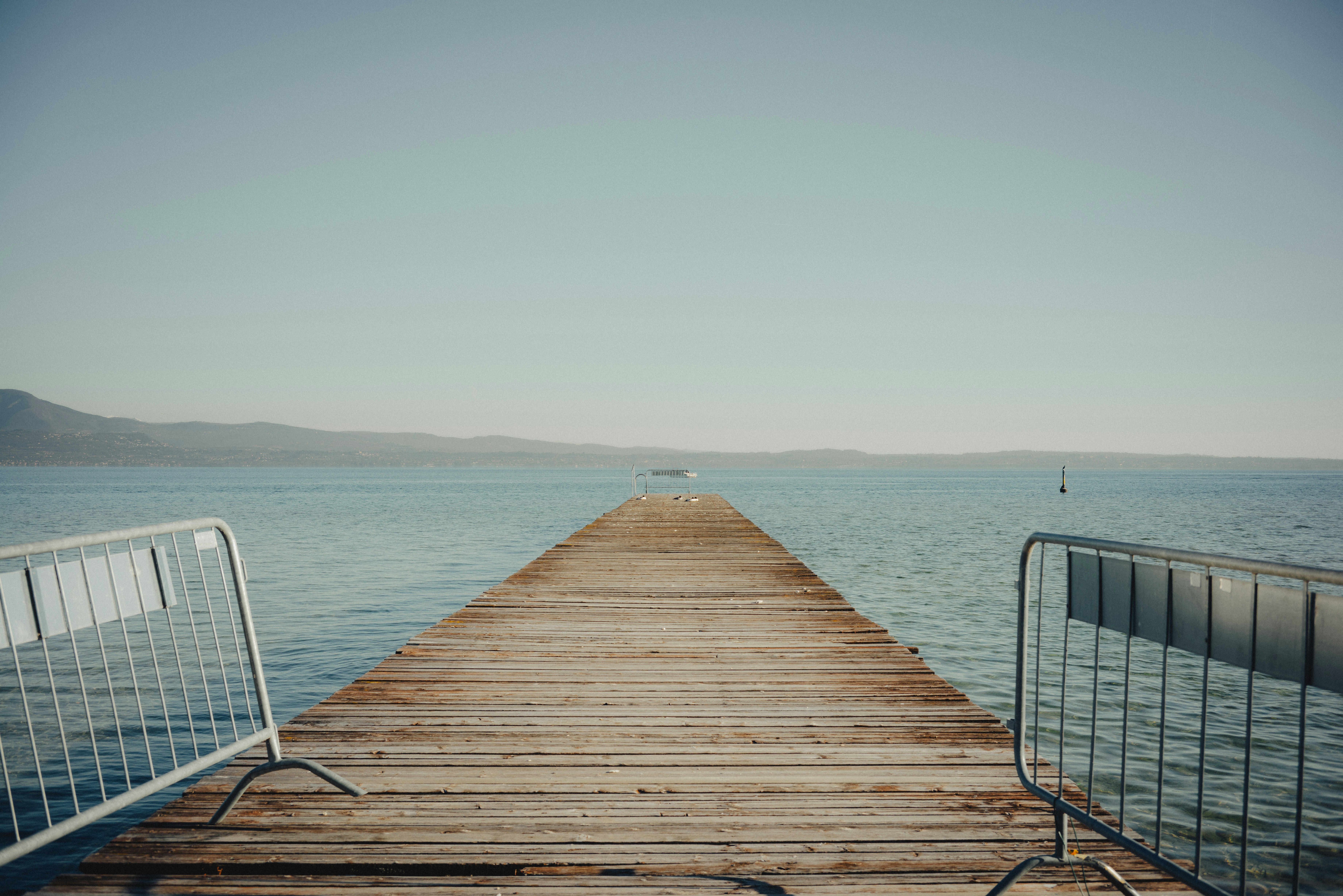 Dock to the Horizon: A Quiet Pier Extends Over Calm Waters