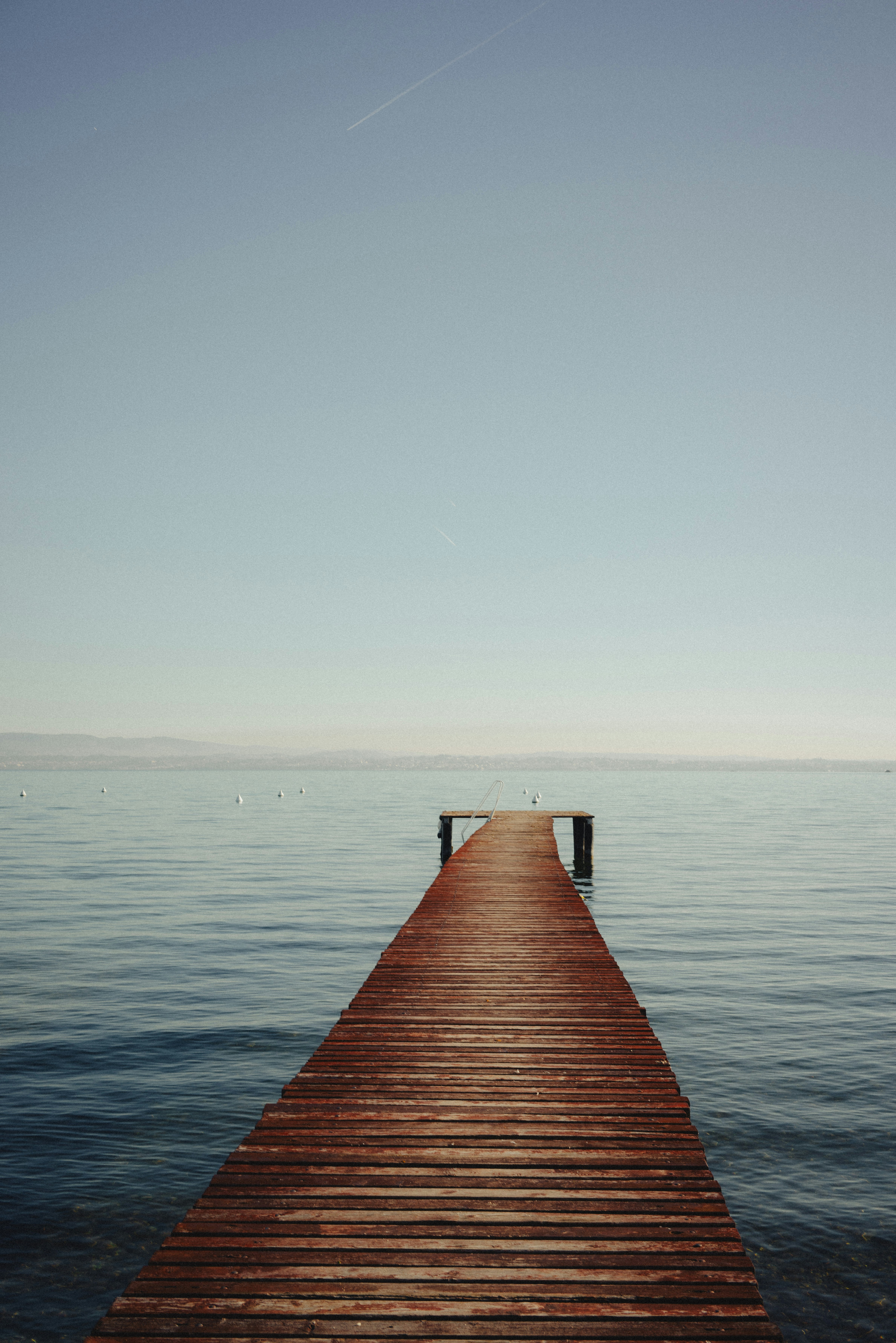 Pier into the Calm: A Wooden Path Extends toward a Distant Horizon