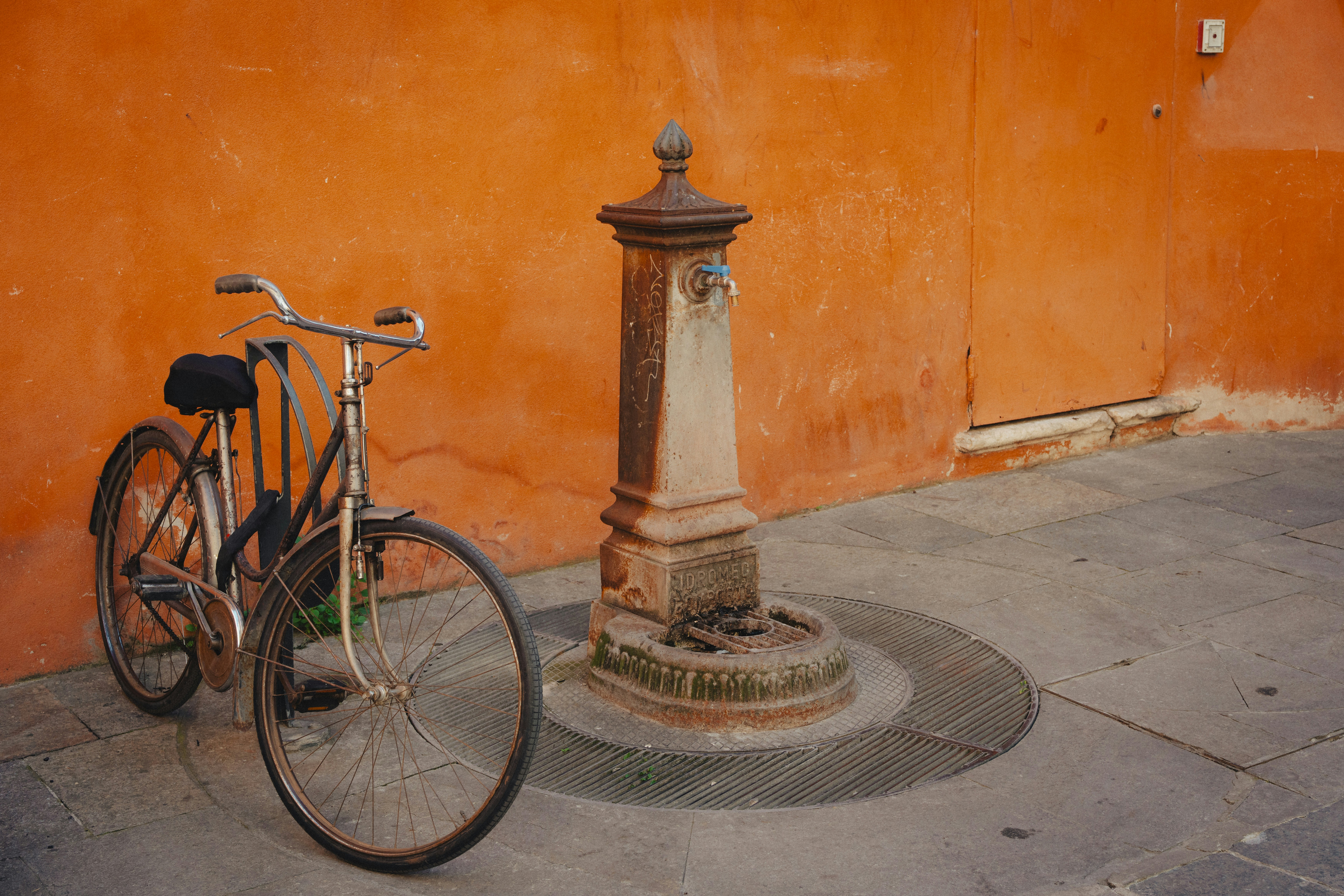 Wheel, Wall, and Water Fountain: A Quiet Street Corner