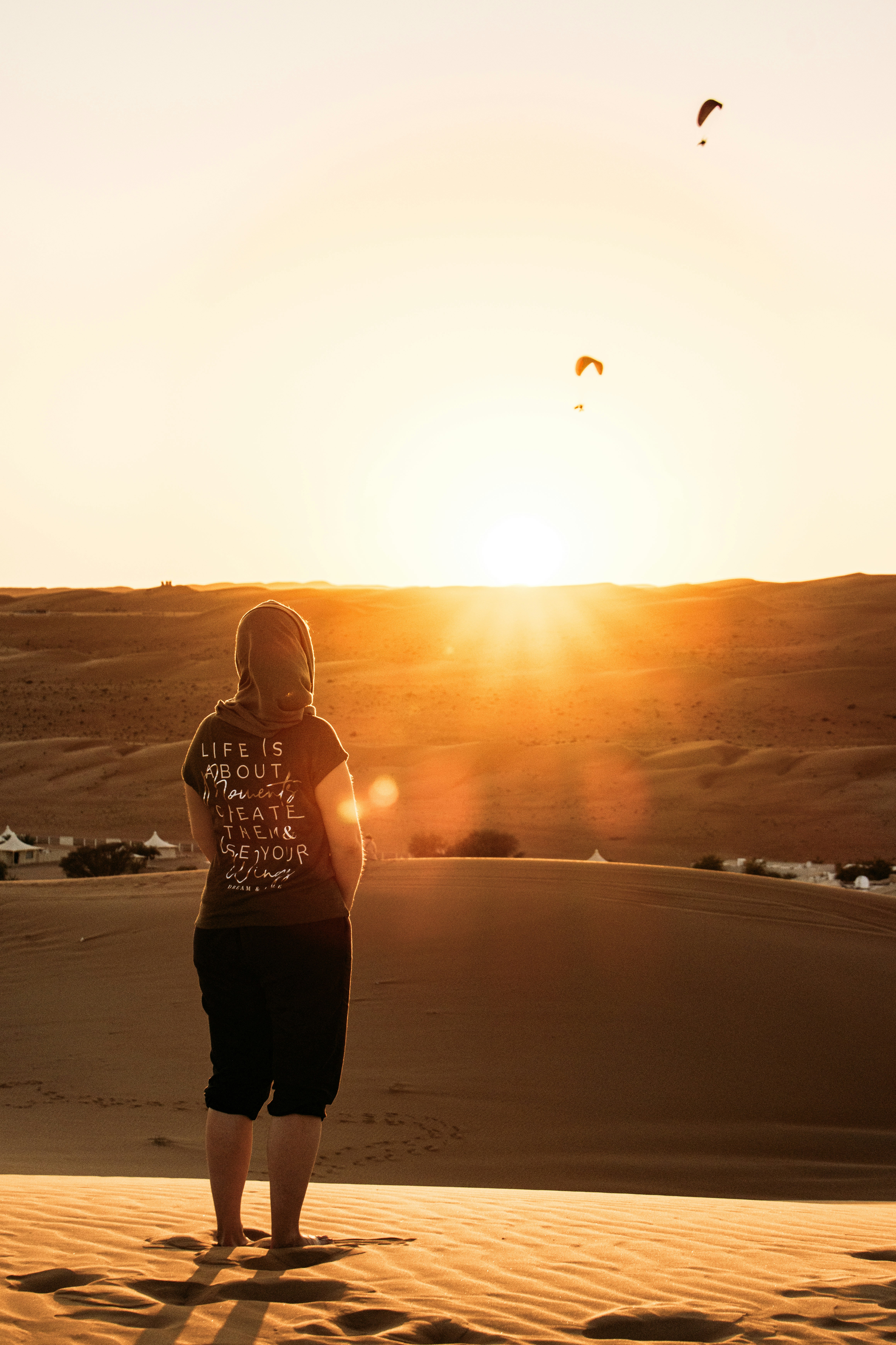 Desert Sunrise: A Hoodie-Clad Figure Watches the Dunes at Dawn