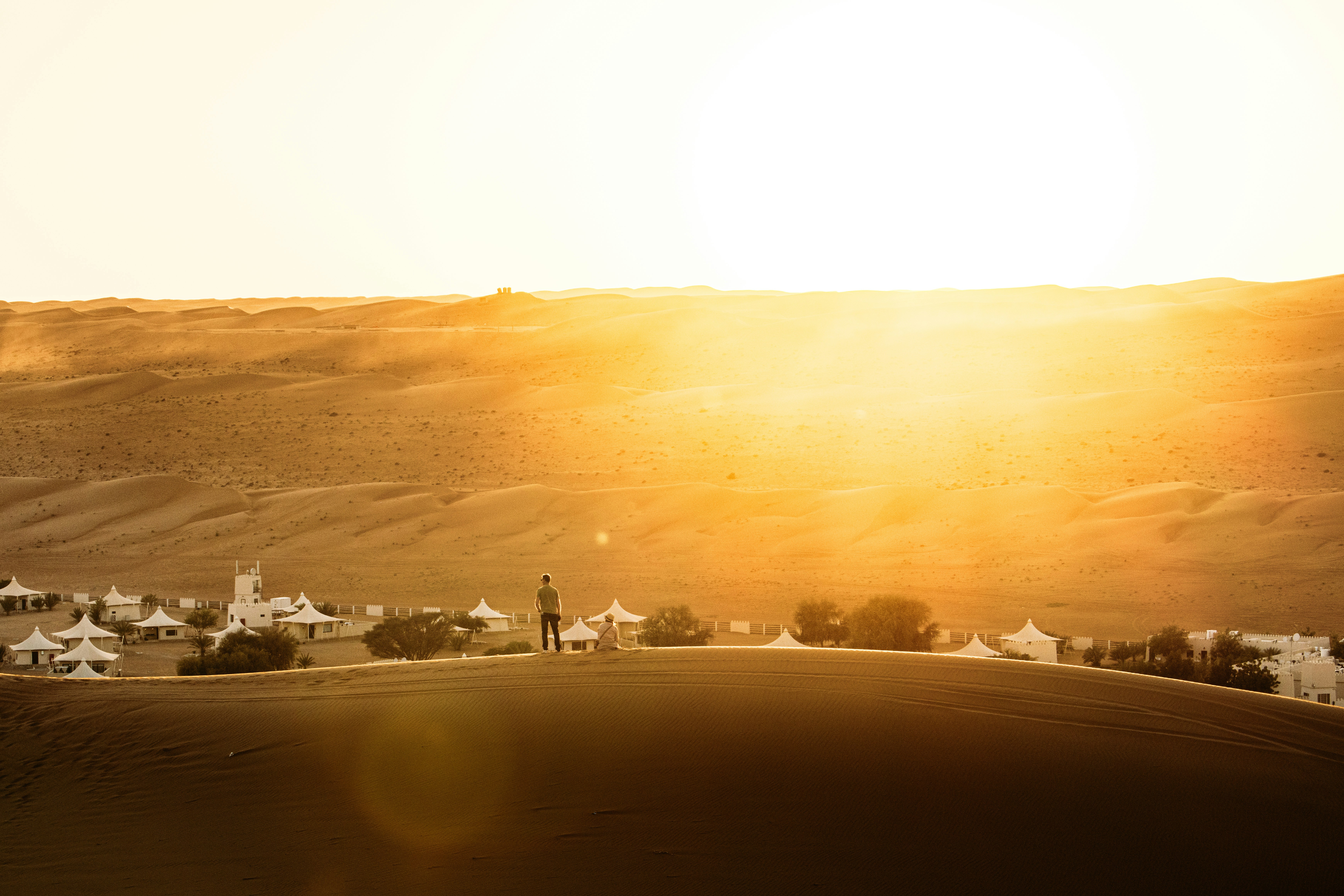 Sunlit Dune Edge: Lone Figure at Dusk