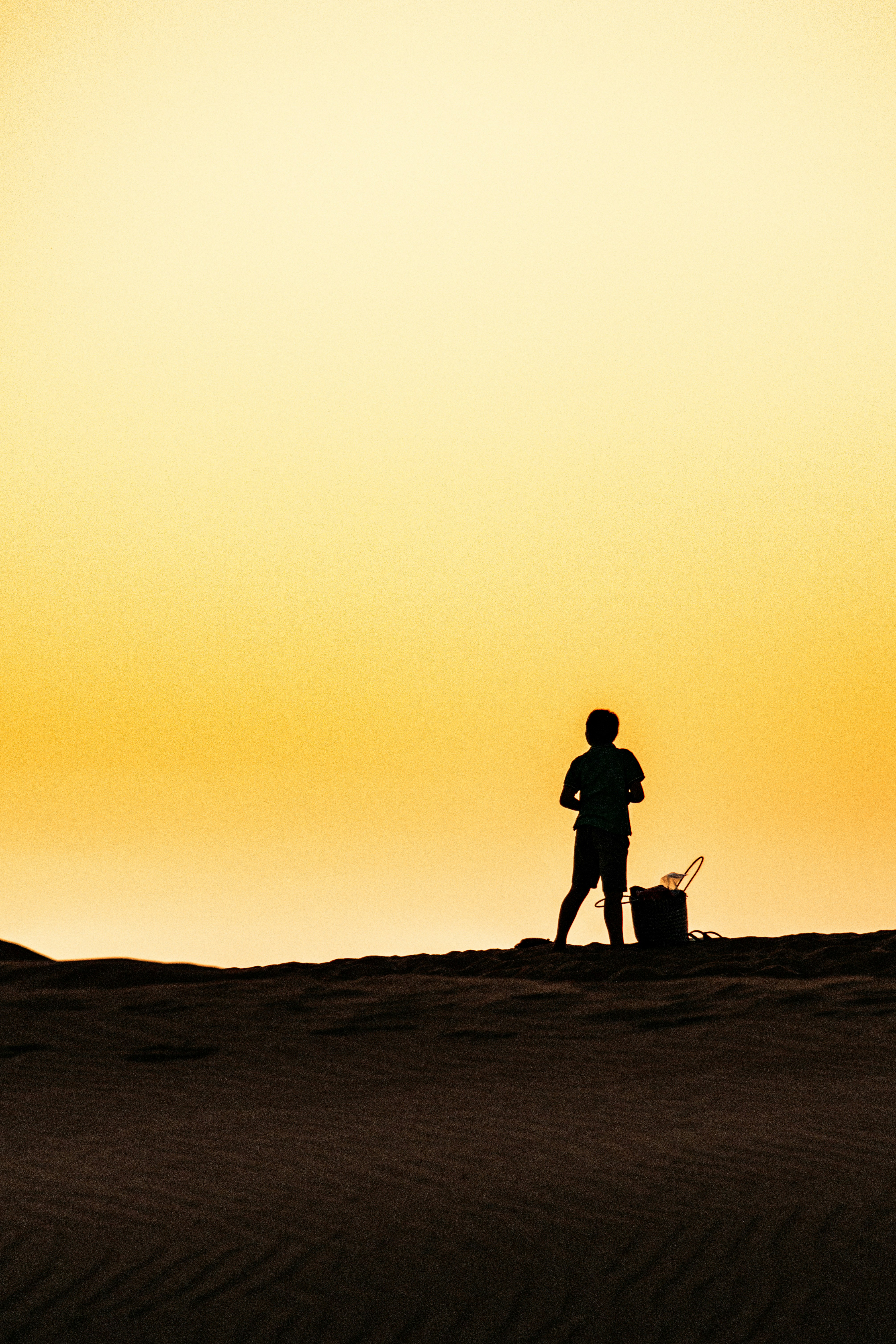 Silhouette at Sunset: A Lone Figure on Dune