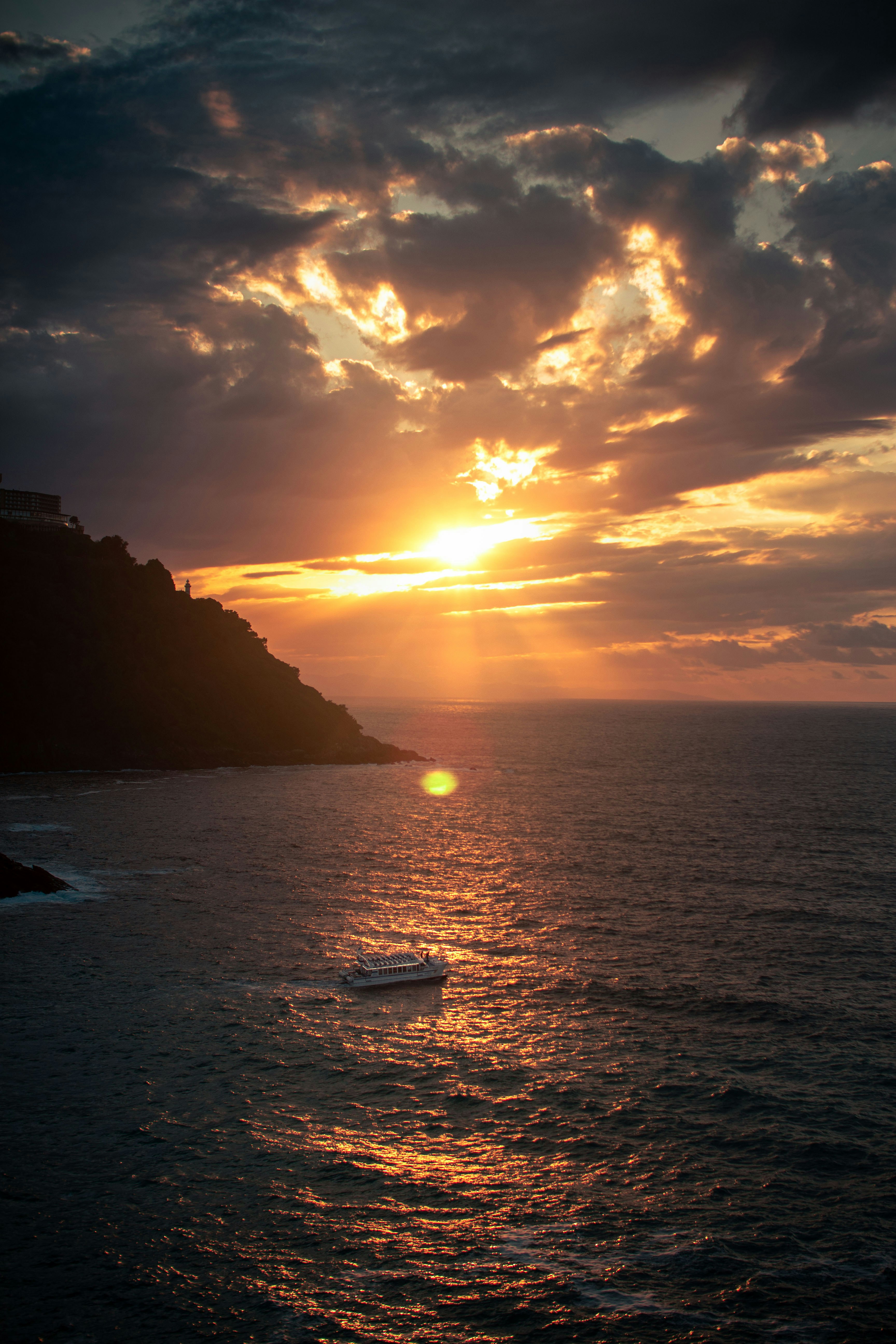 Sunlit Cliffs and a Veiled Boat: A Seaside Dusk