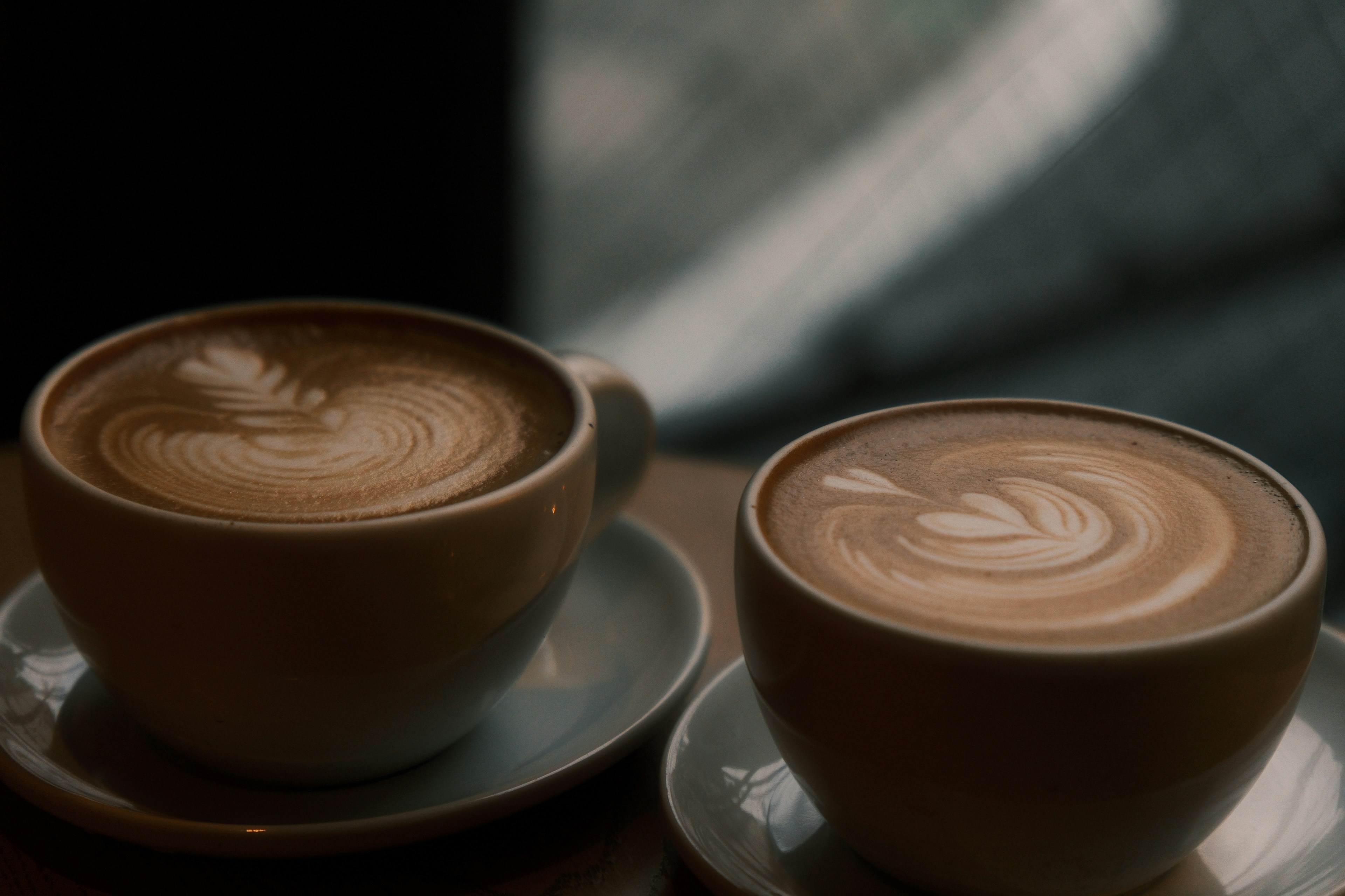 Dual Espresso Moments: Latte Art on Two Saucered Mugs