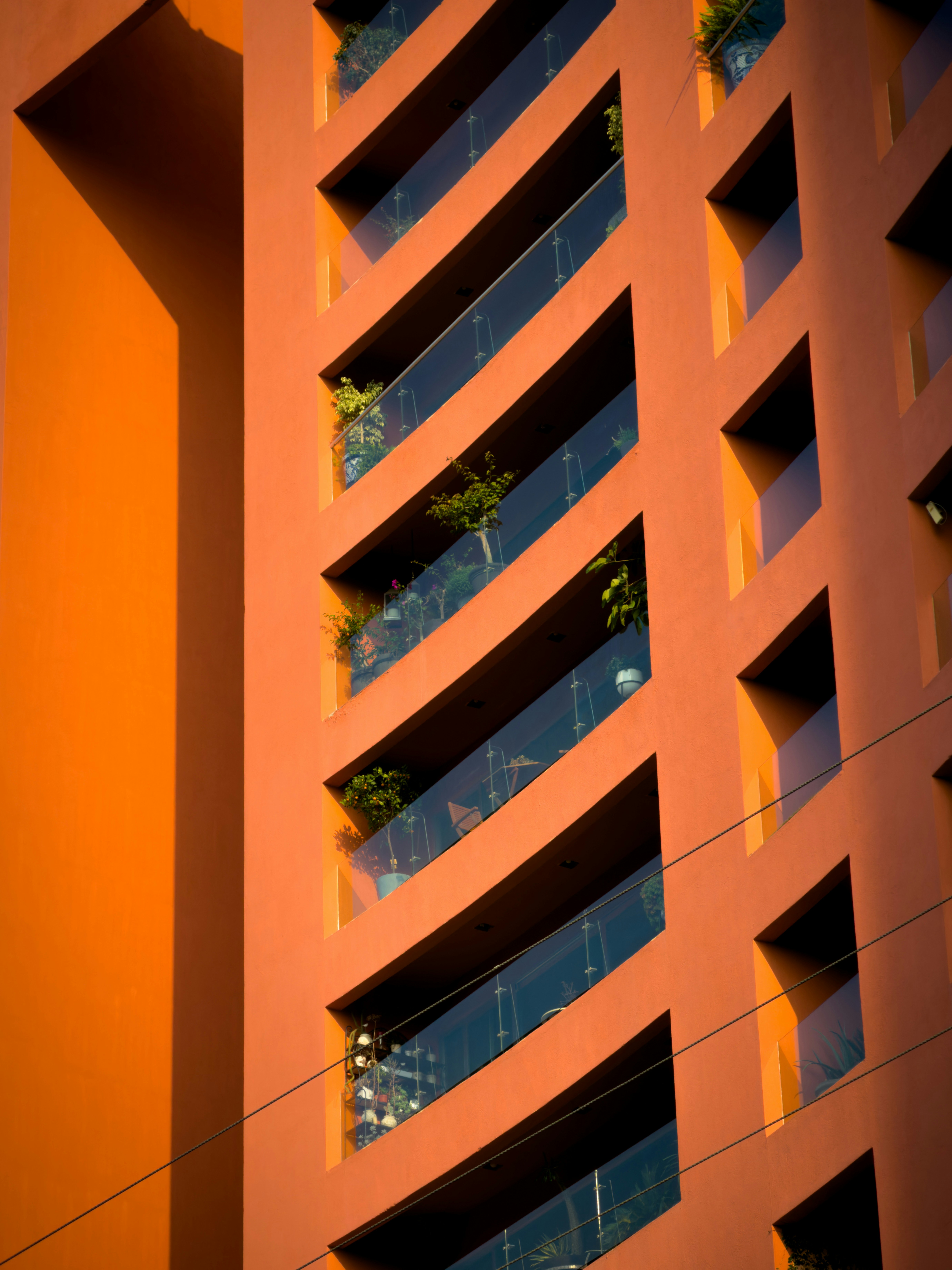 Orange Facade: A Cadence of Balconies and Sunlit Geometry