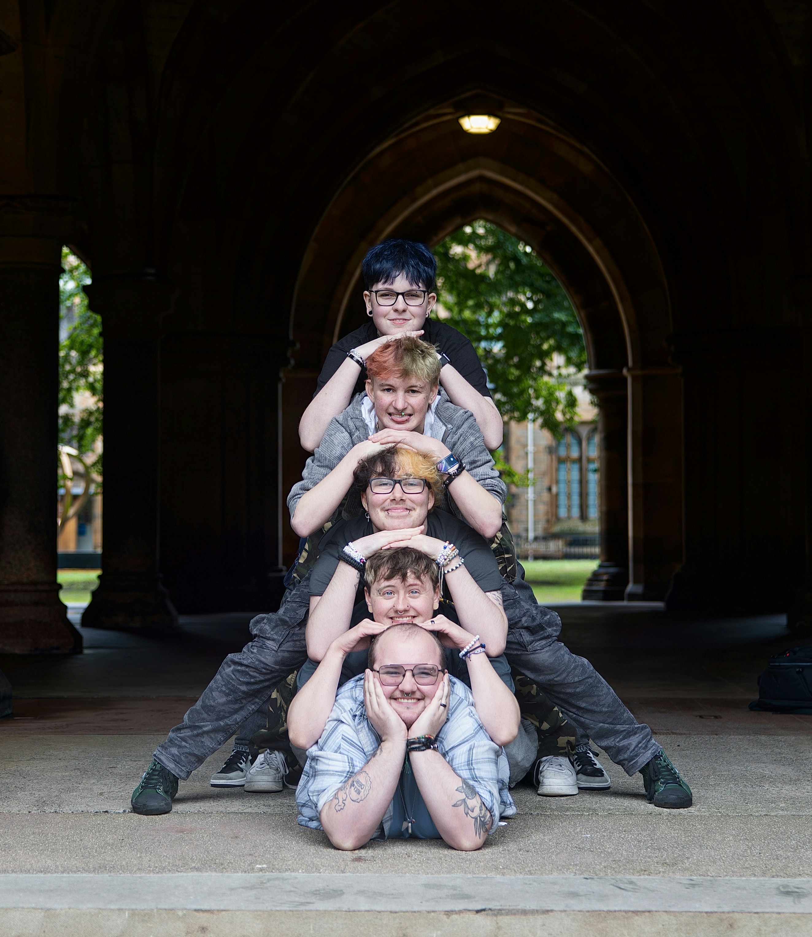 Graceful Pyramid: Five Friends Form a Tower Under the Arch