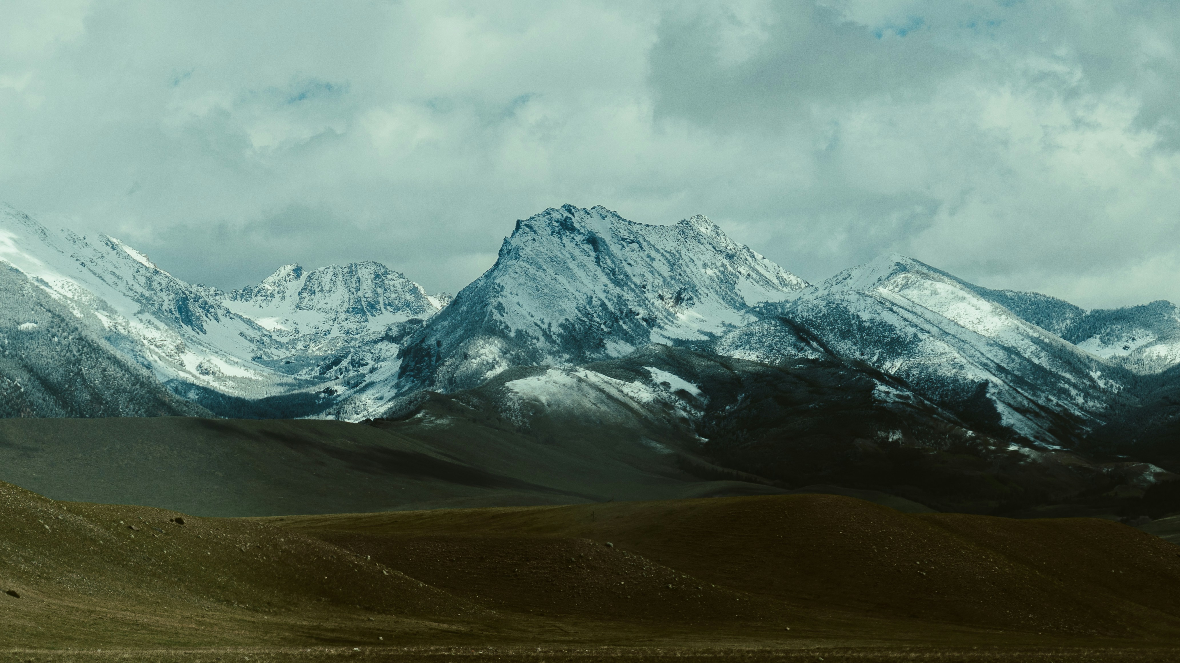 Snow-kissed Alps Under a Moody Sky