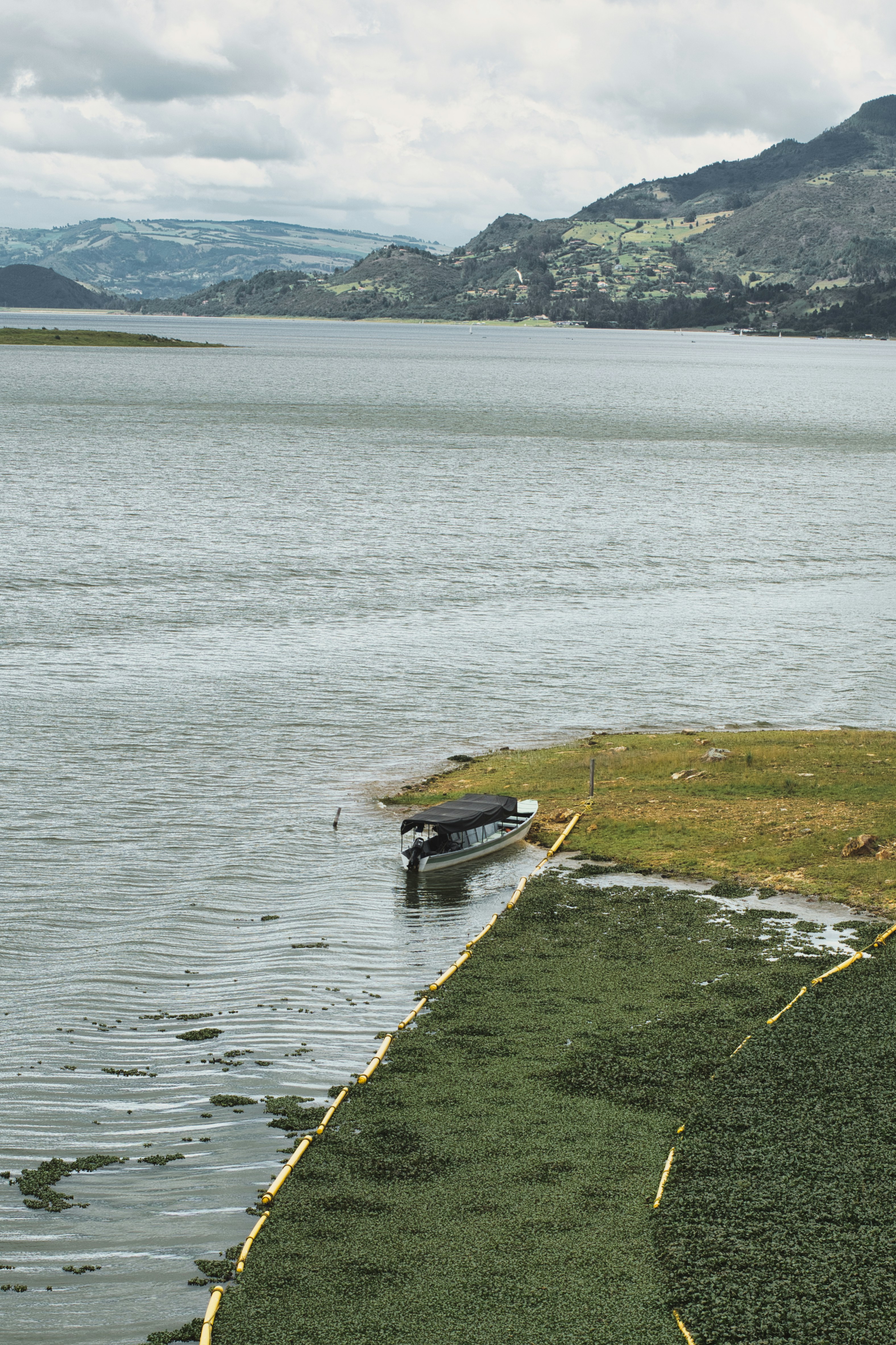 Boat at the Threshold: A Quiet Shore Between Water and Hills