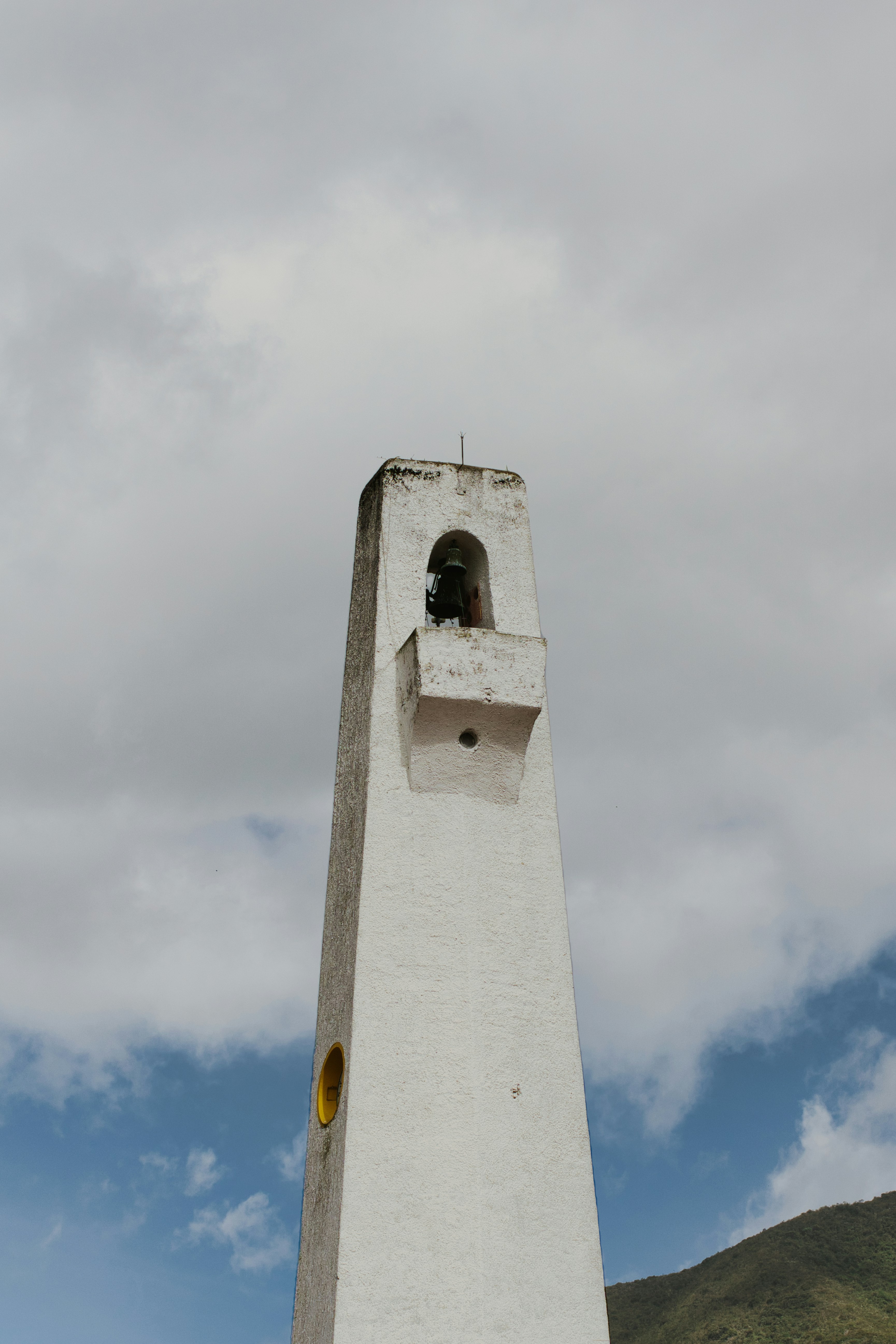 Obelisk of light: a solitary bell-tower piercing a cloudy sky