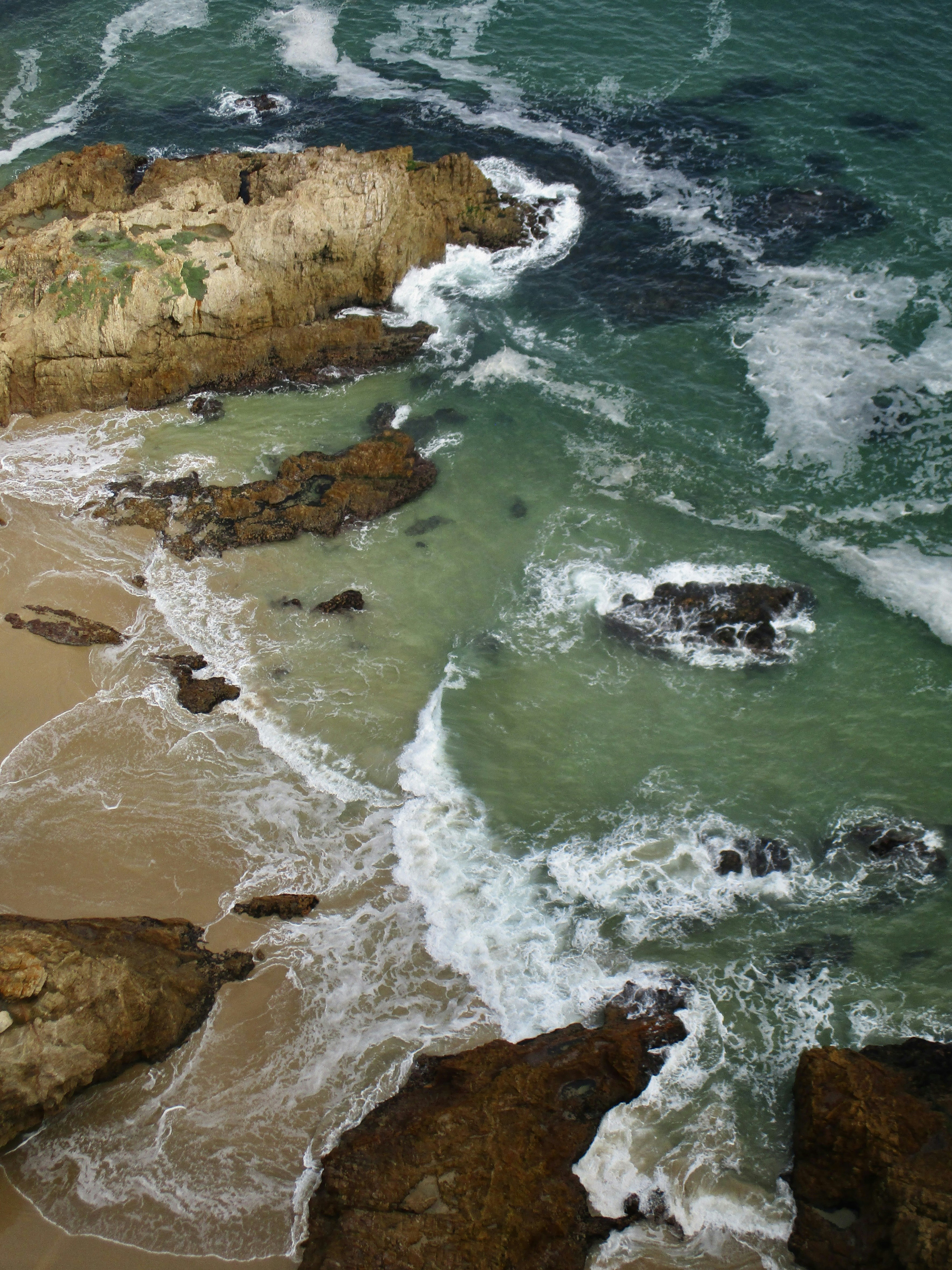Ocean Edge: Aerial Dance of Waves and Rocks