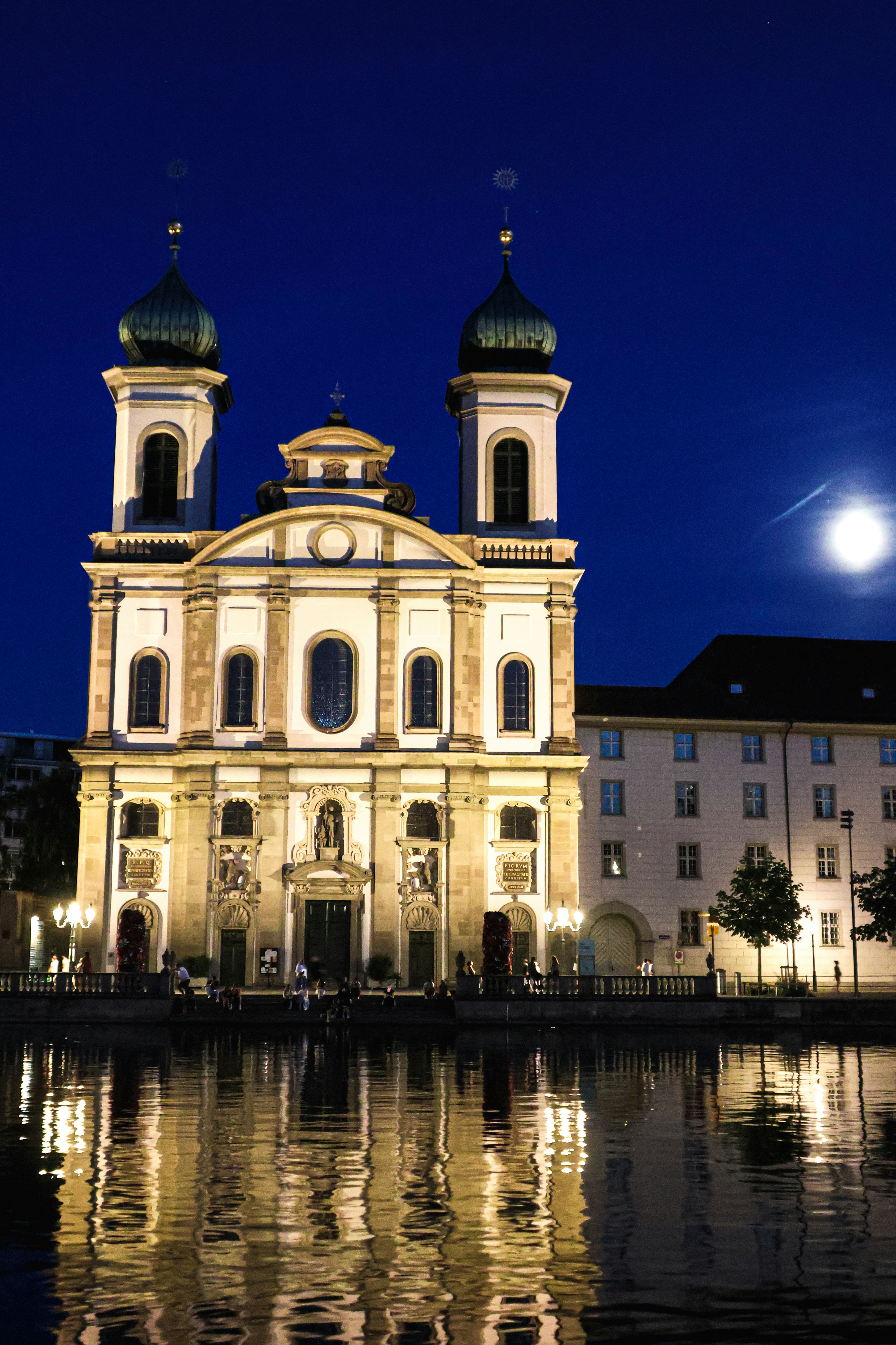 Moonlit Facade Reflections: Baroque church beside a shimmering river