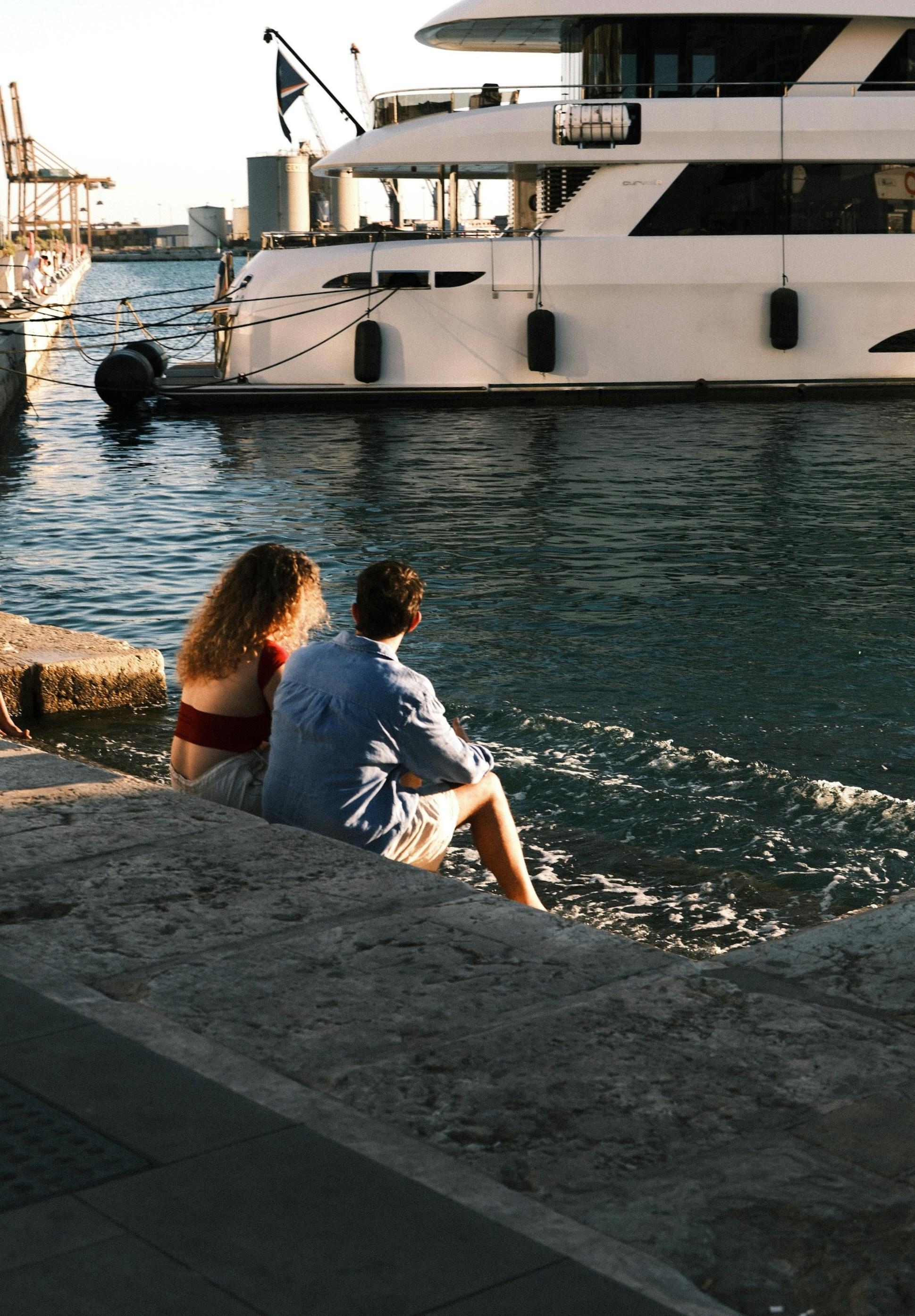 Harbor Quiet: Couple by the Dock with a Yacht Backdrop