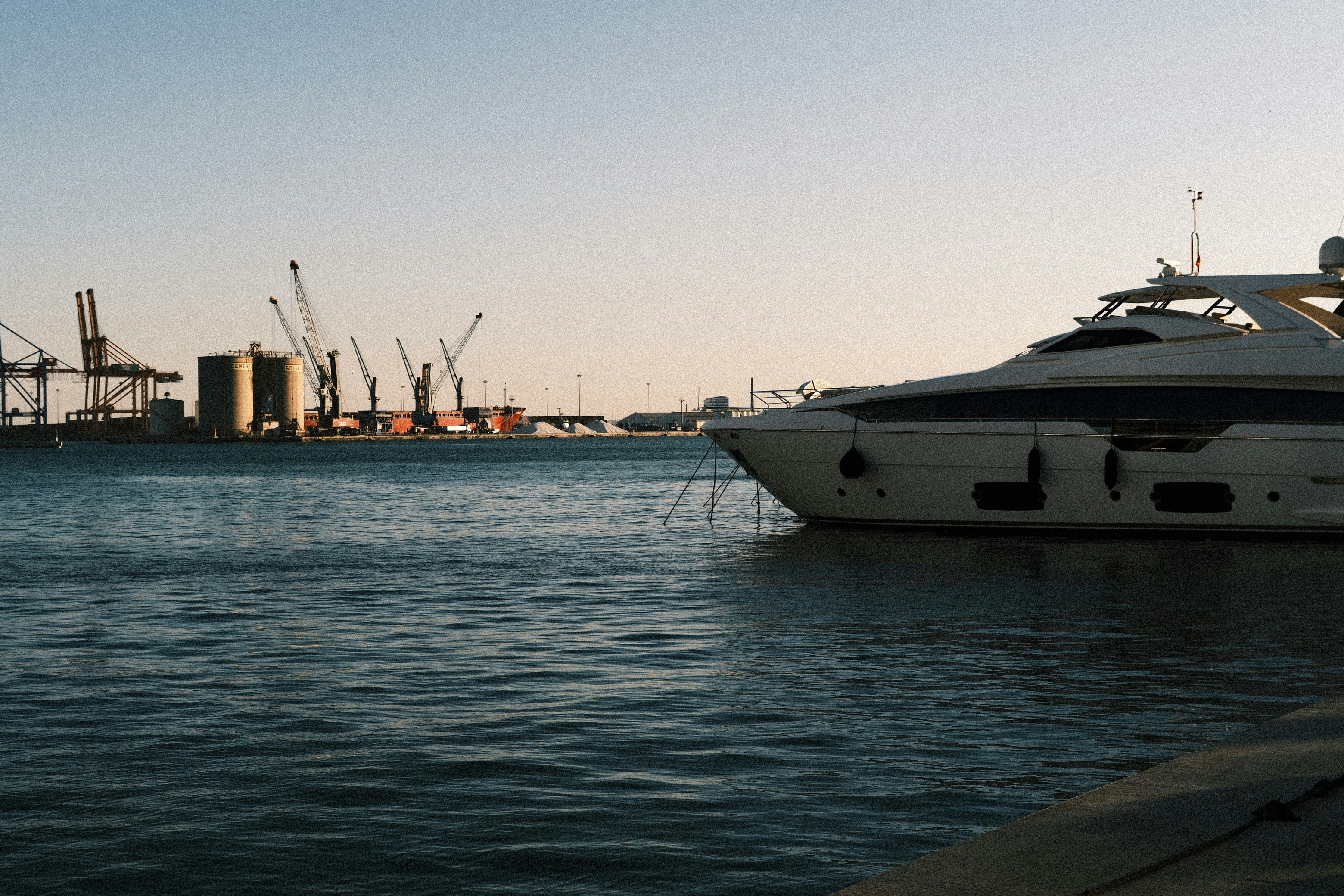 Harbor Majesty: Yachts and Cranes Against a Dusk Sky