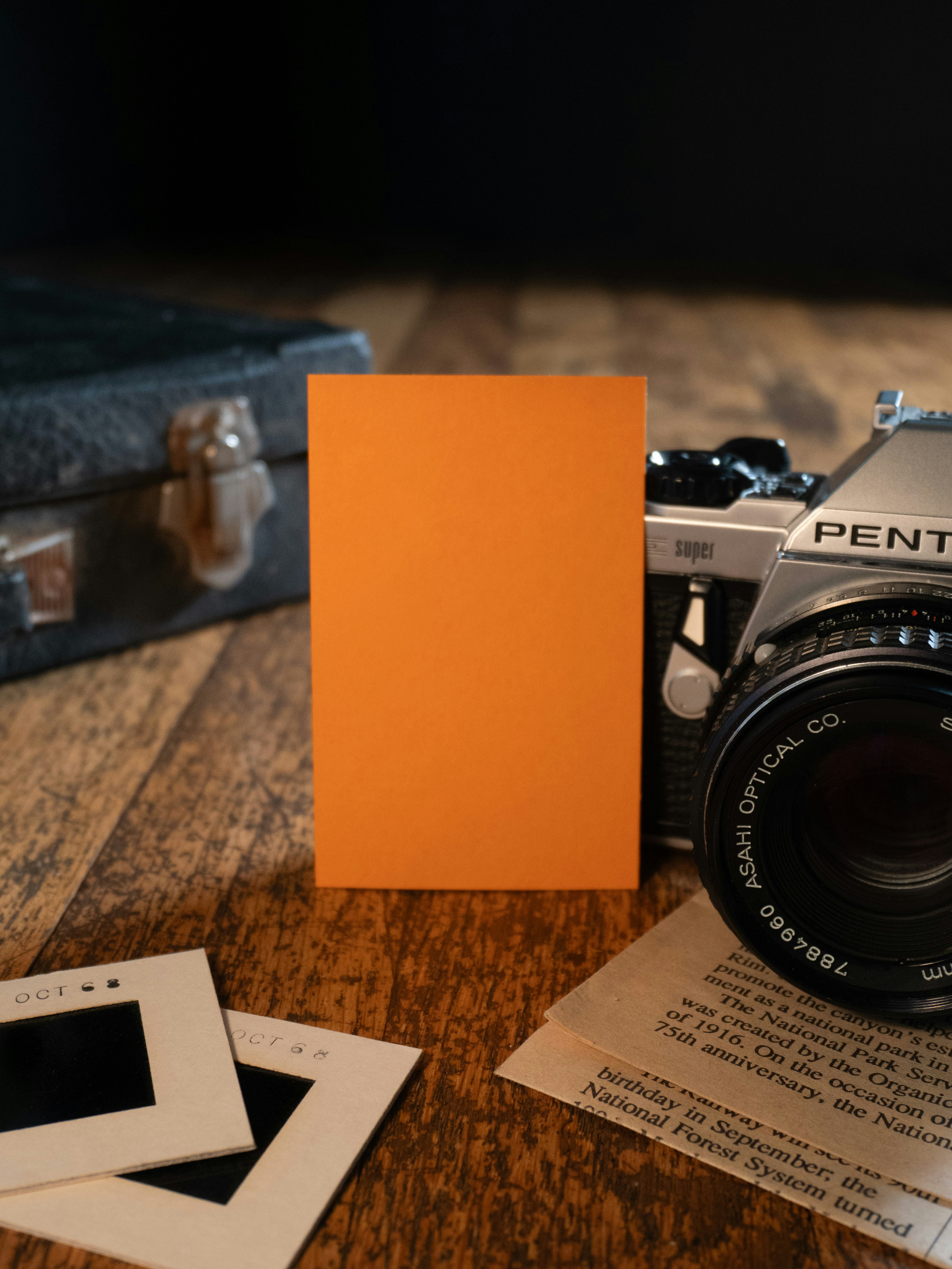 A Snapshot of Vintage Tools: Orange Card Between Camera and Polaroids