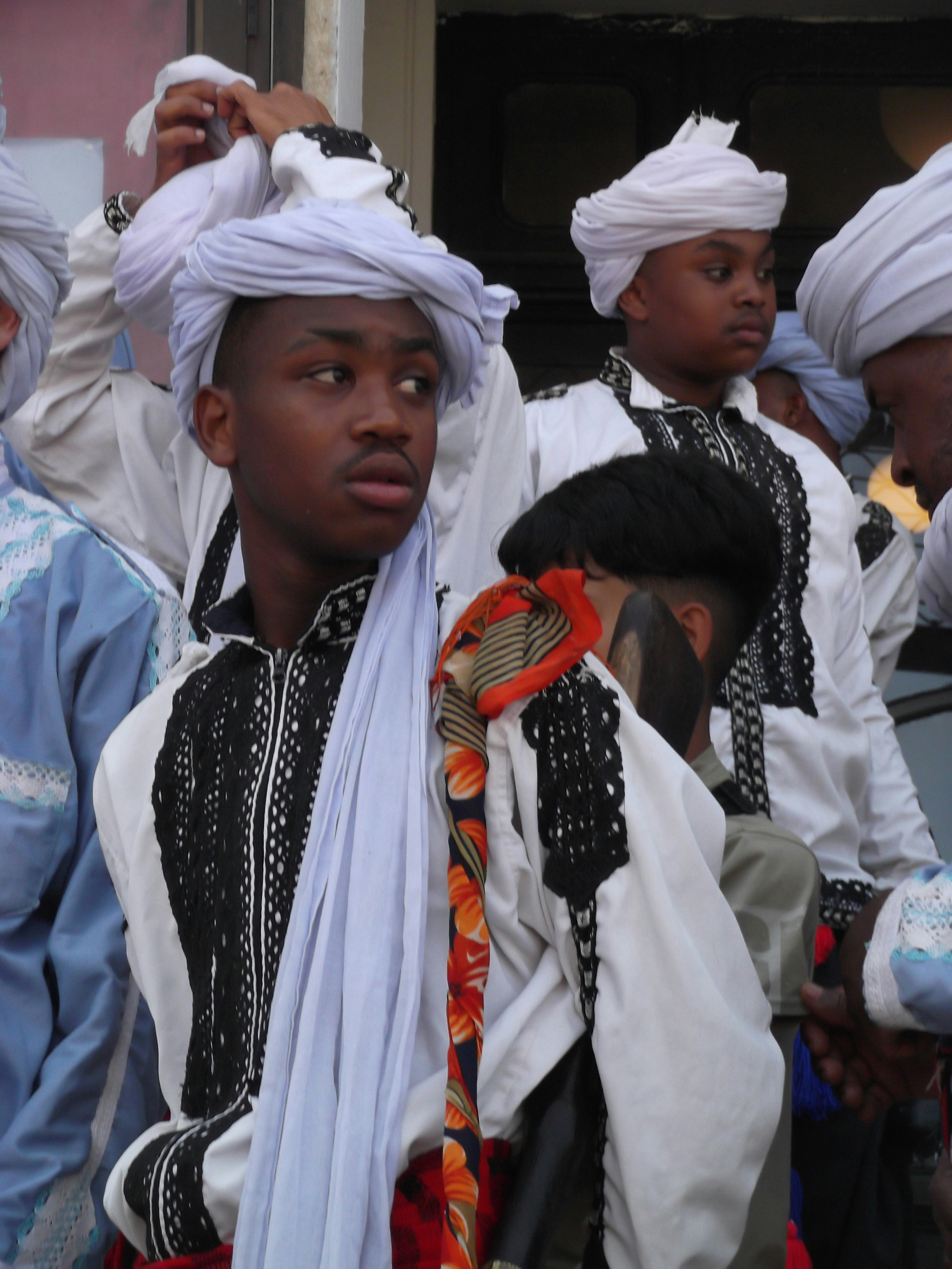 Turbaned Youths in White and Black Attire At a Public Gathering