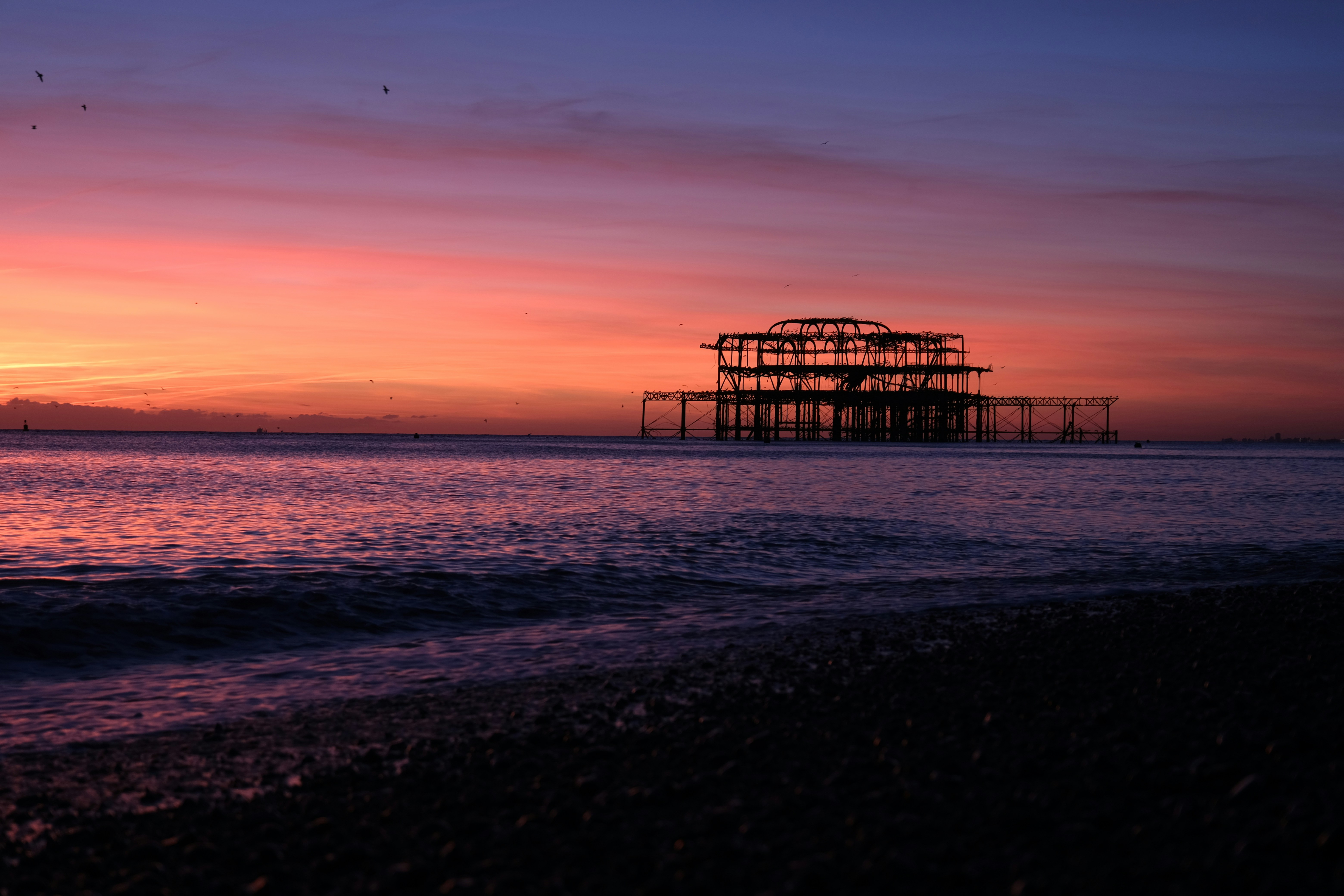 Silhouette at Dusk: The Pier Skeleton Against a Violet Sea