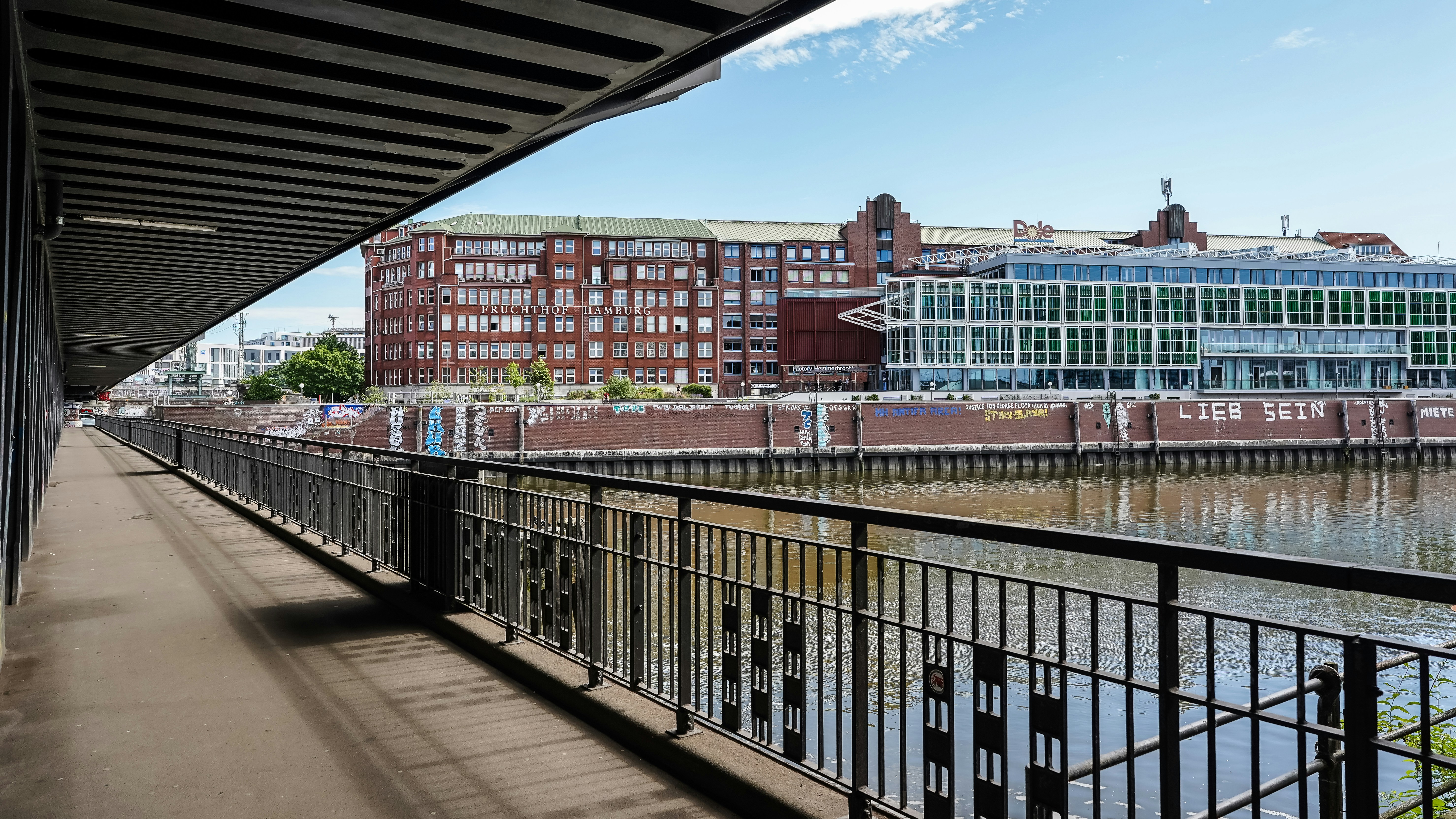 Riverside Walkway Framed by Urban Brick and Glass