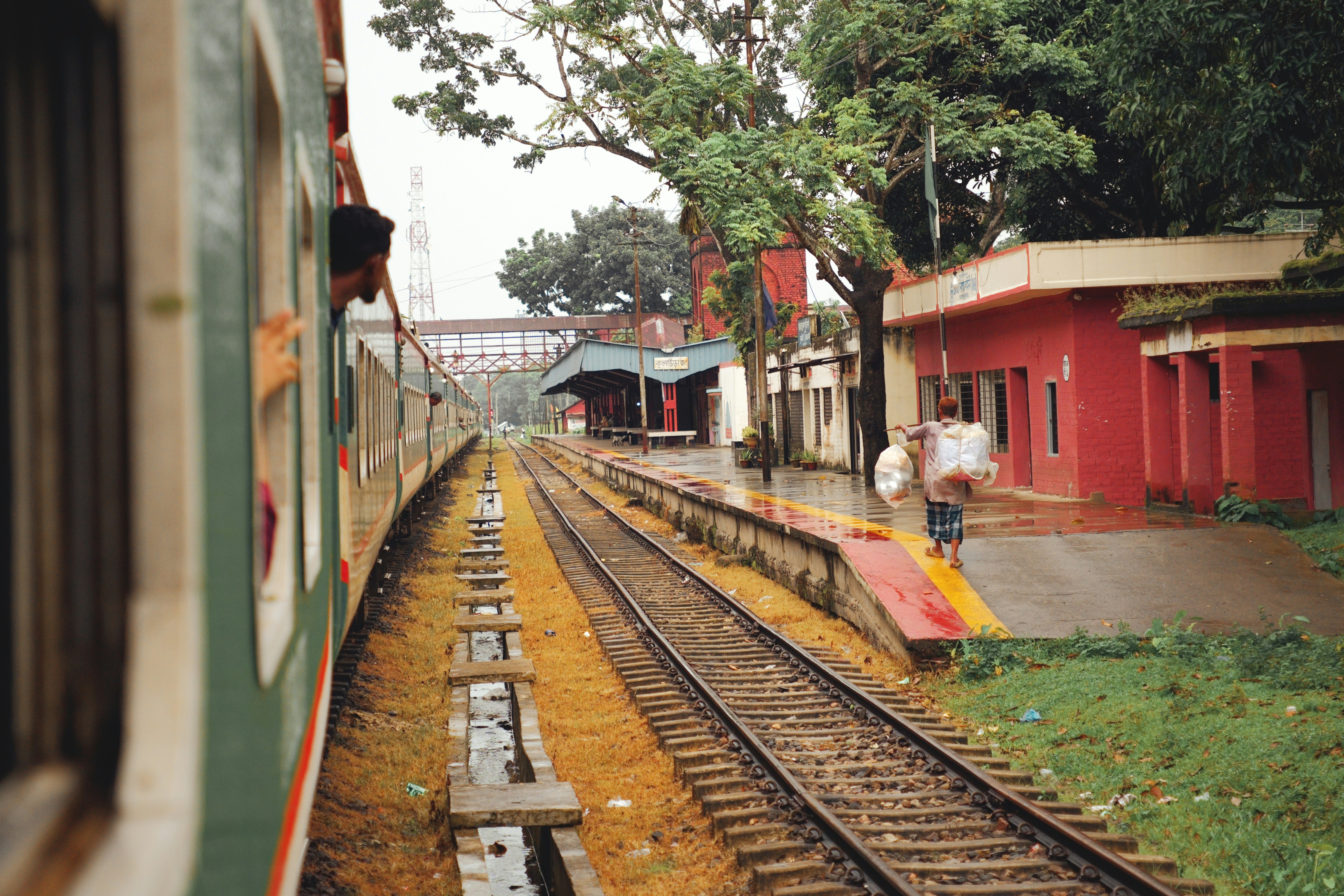 Platform Echoes: A Distant Train Leaves Footsteps in Rainy Light