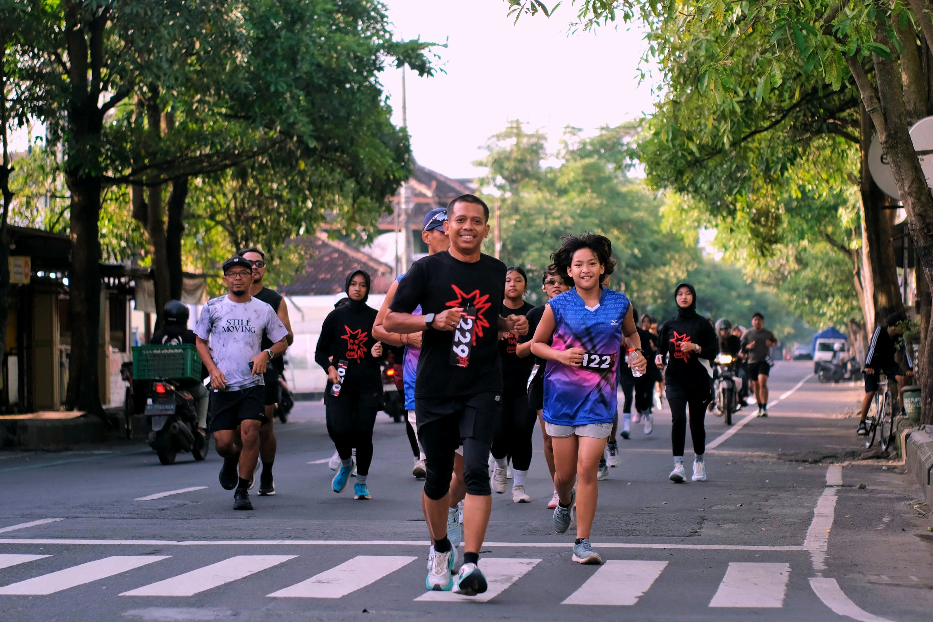 Runners Lead the Morning Parade Down a Tree-Lined Street