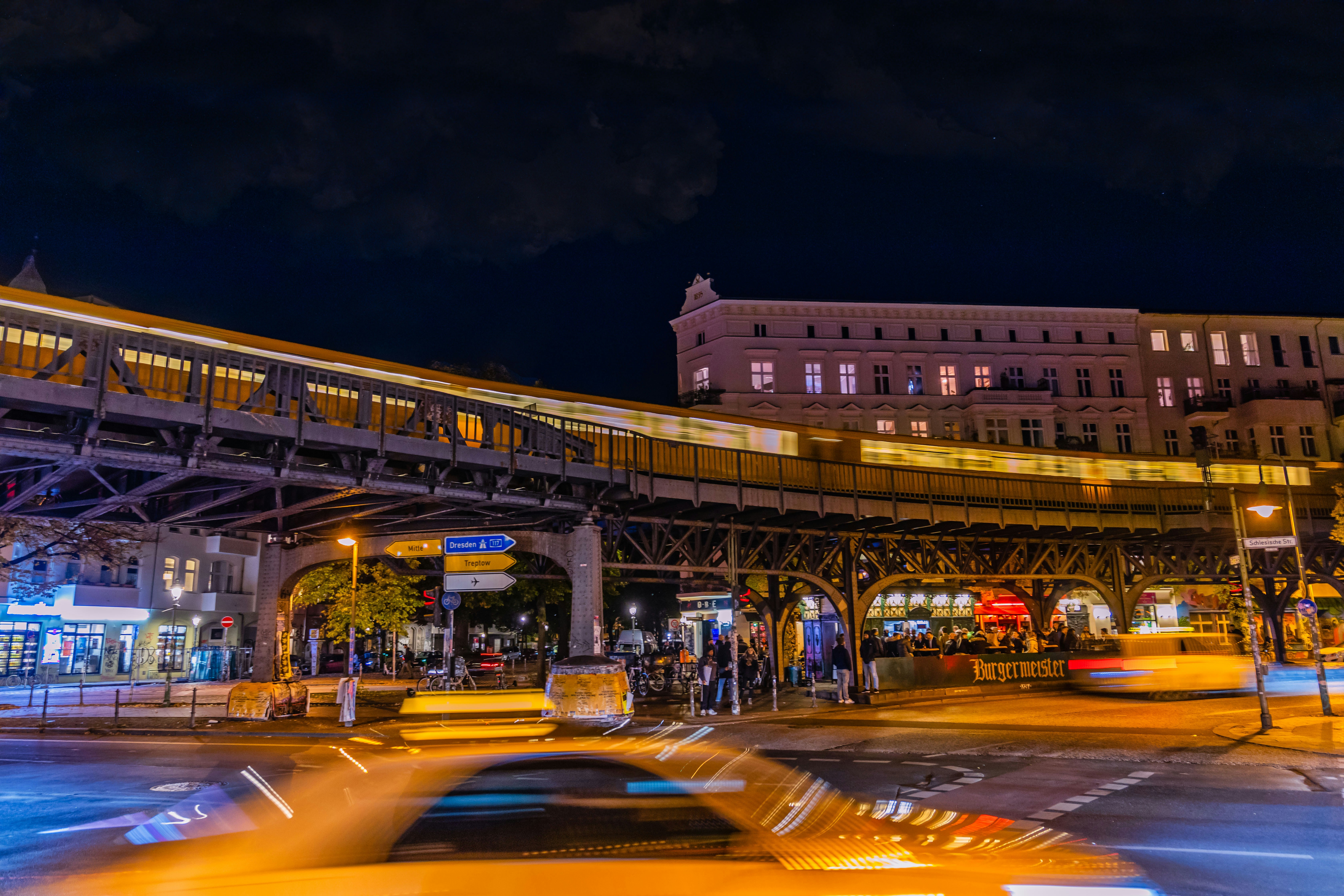 Night Crossing: A Blurred Tableau of City Transit Under the Elevated Rails