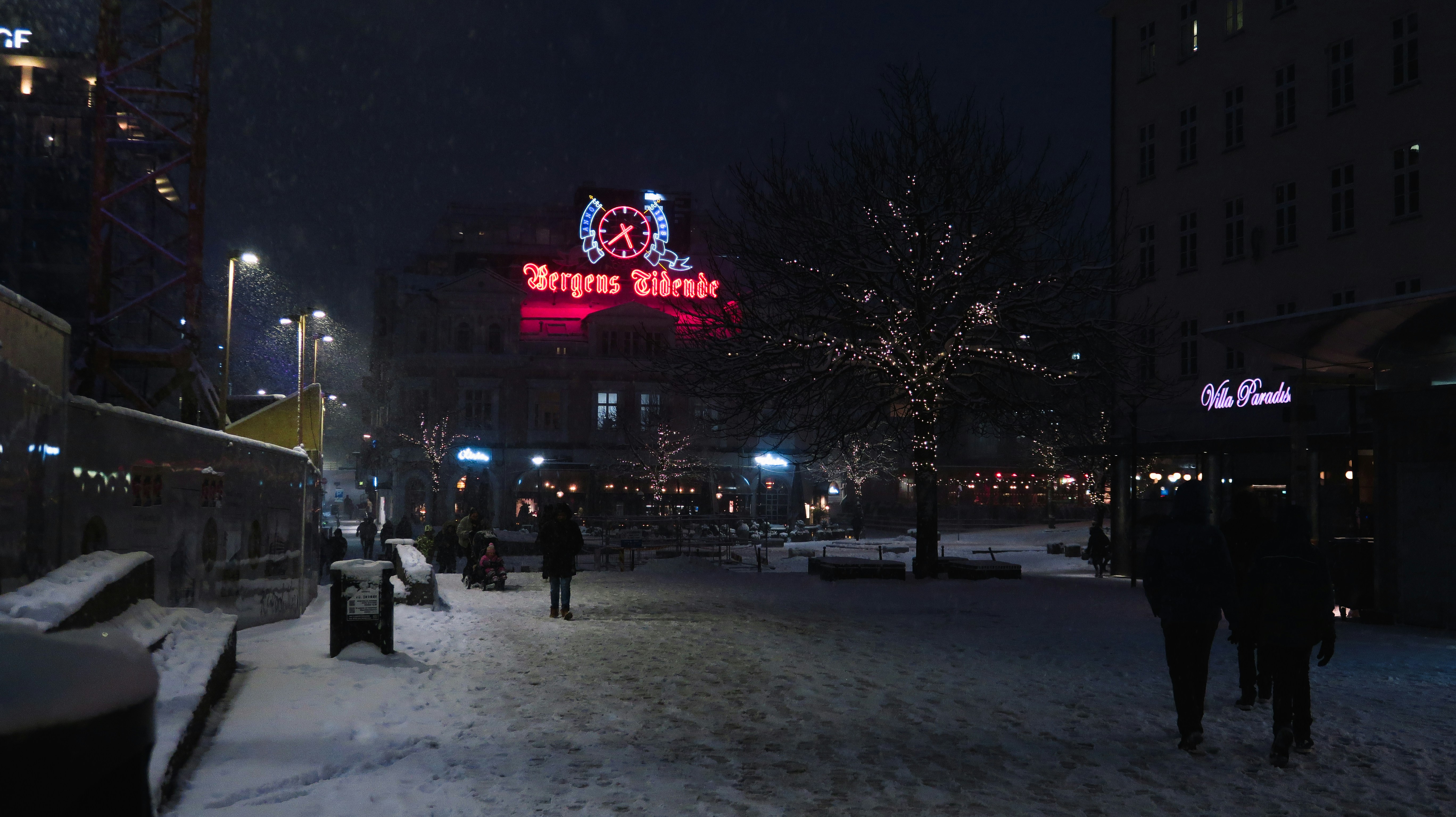 Night at the Snowy Plaza: Neon Sign and Ice-Covered Walkway