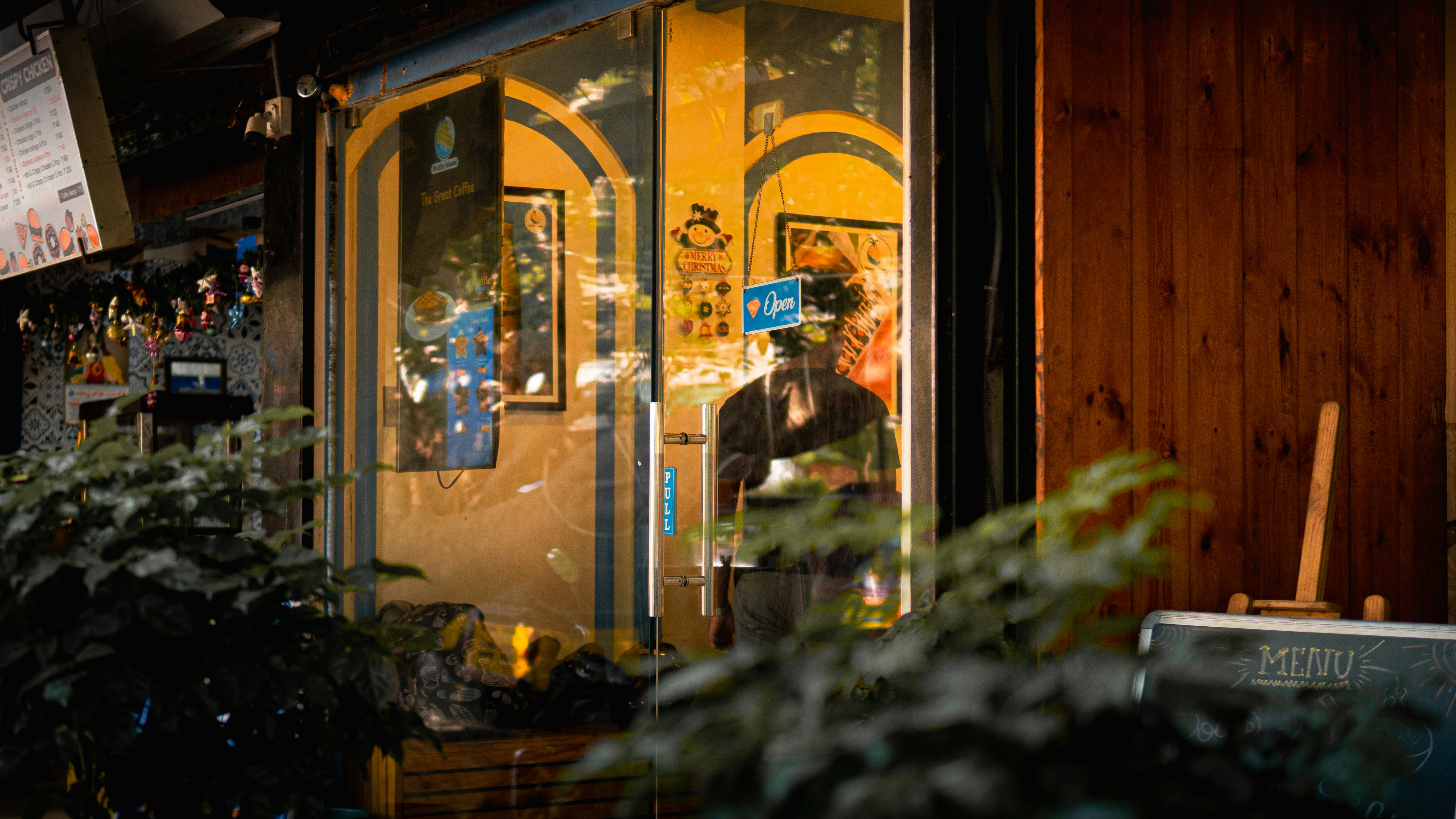 Golden Archways and Reflections: A Cozy Café Front in Dappled Evening Light