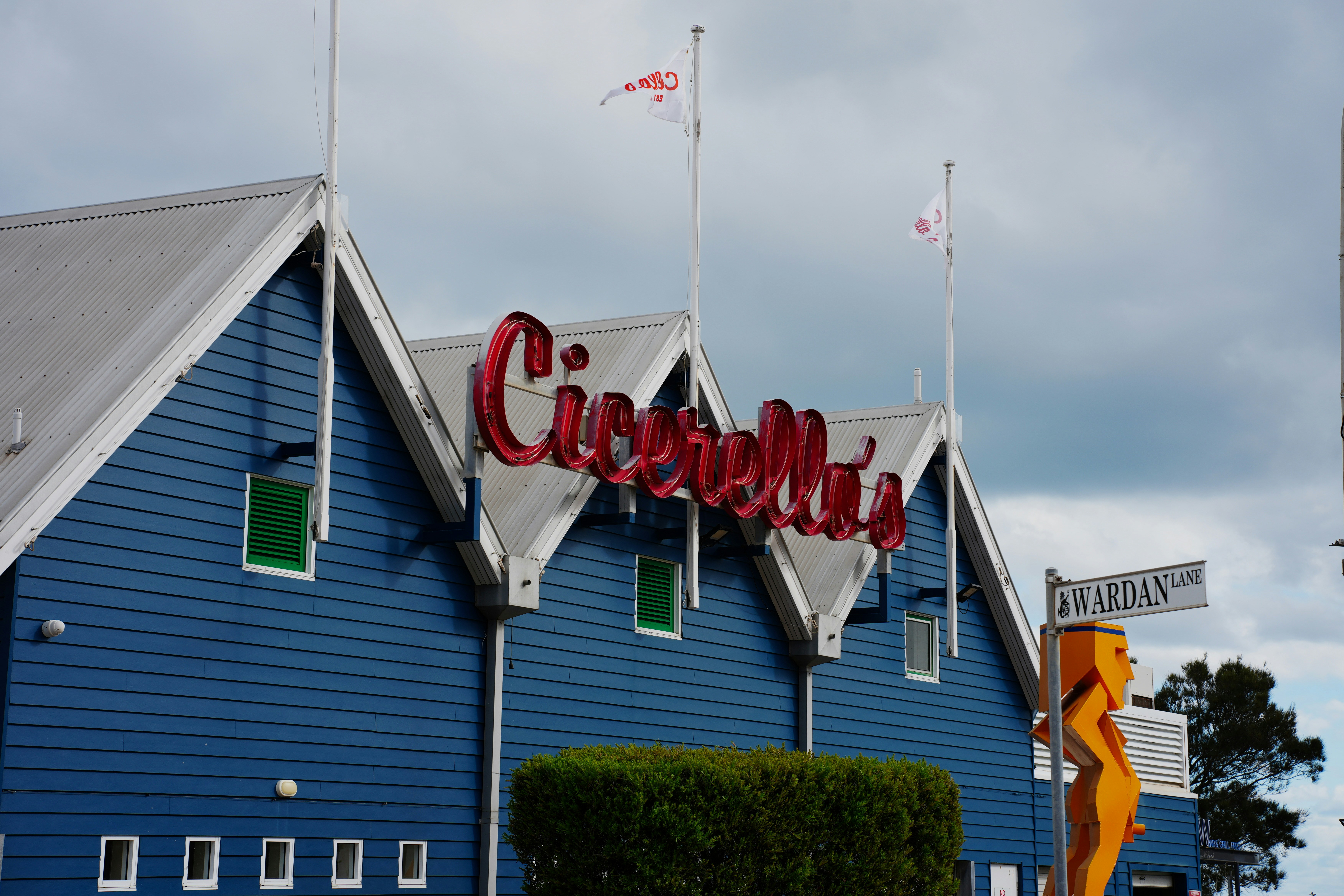 Neon Sign on the Blue Chalet: A Coastal Diner's Facade