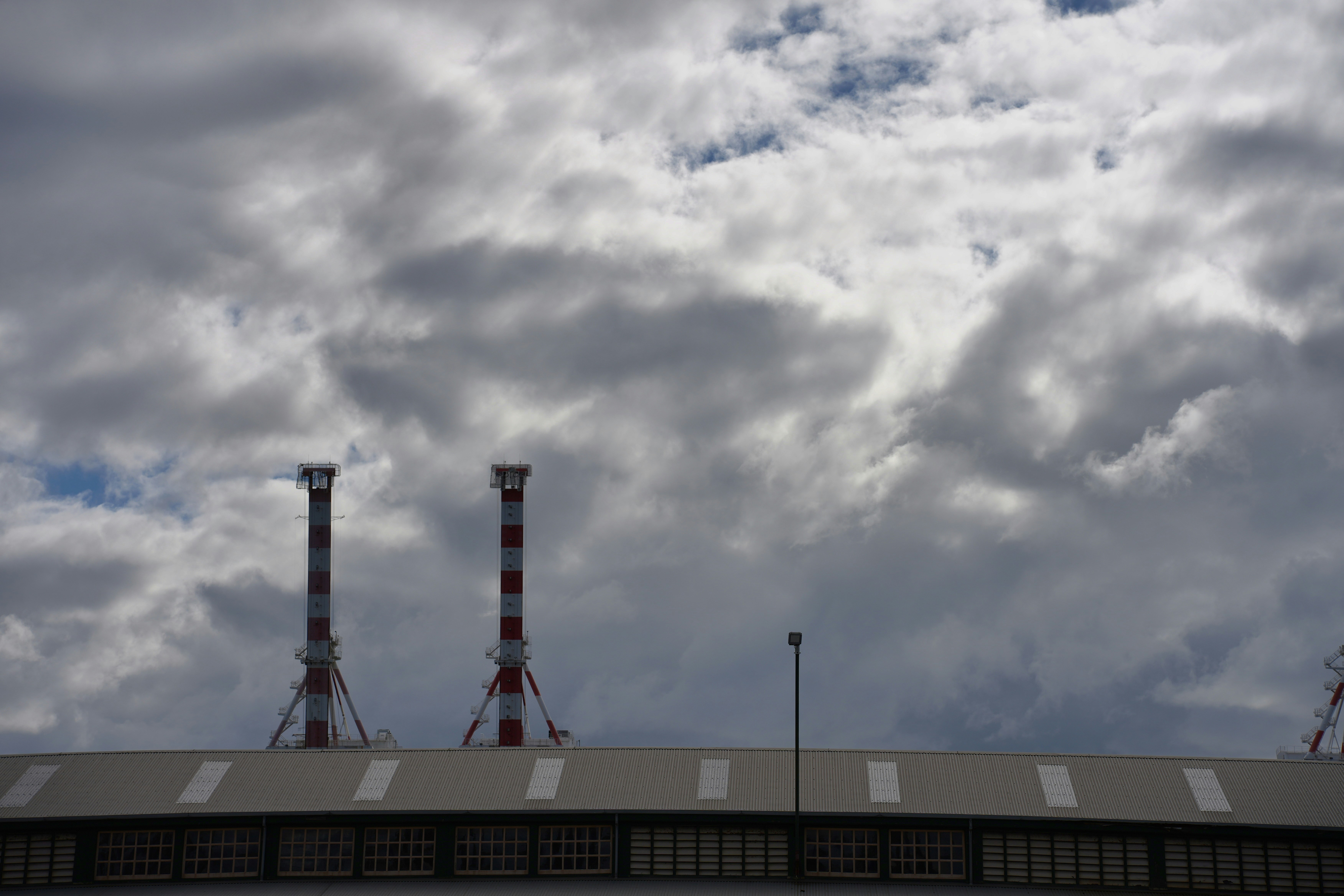 Overcast Skyline: Industrial Silhouettes Beneath Stormy Skies