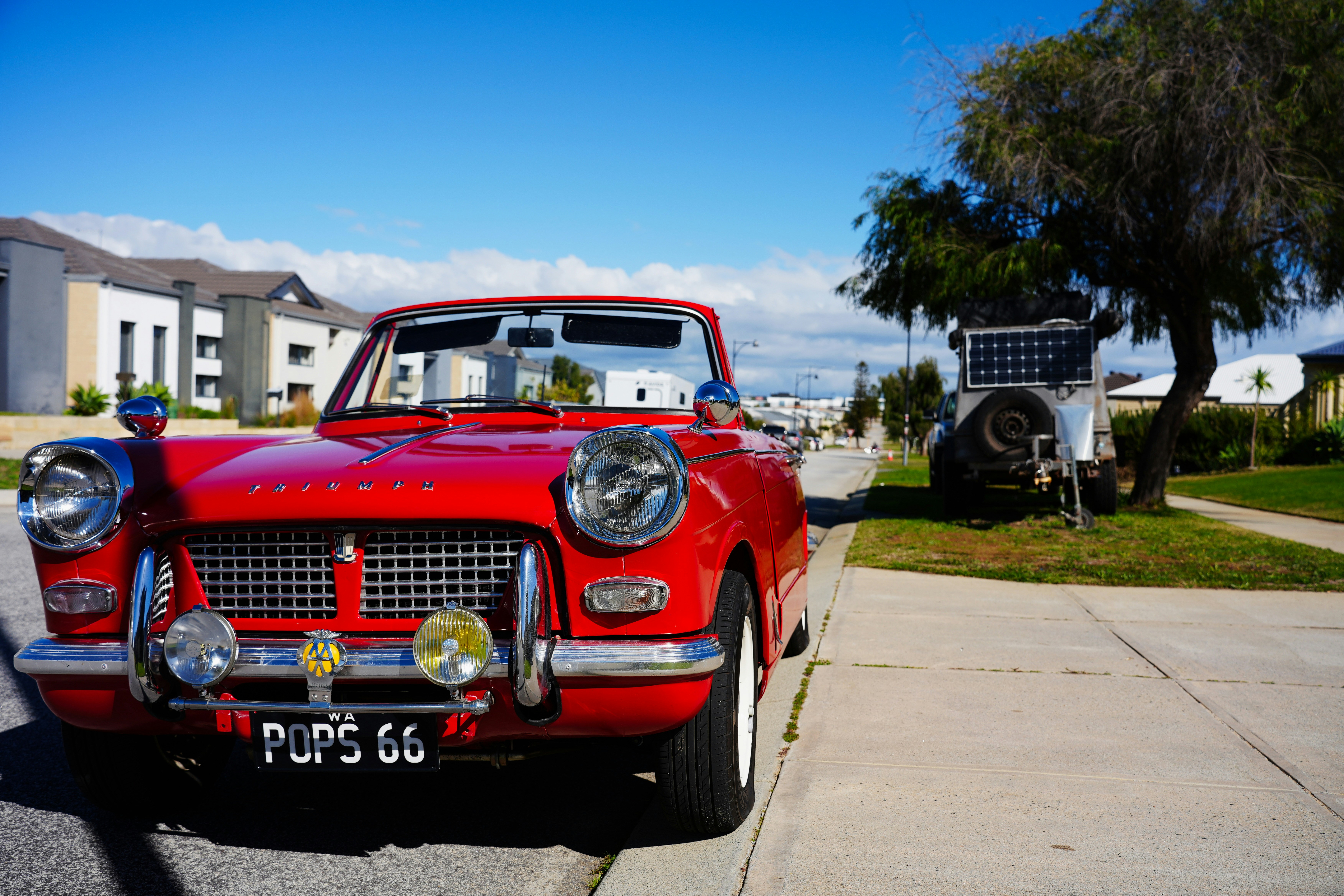 Red Classic: A Vintage Convertible Anchoring a suburban Street
