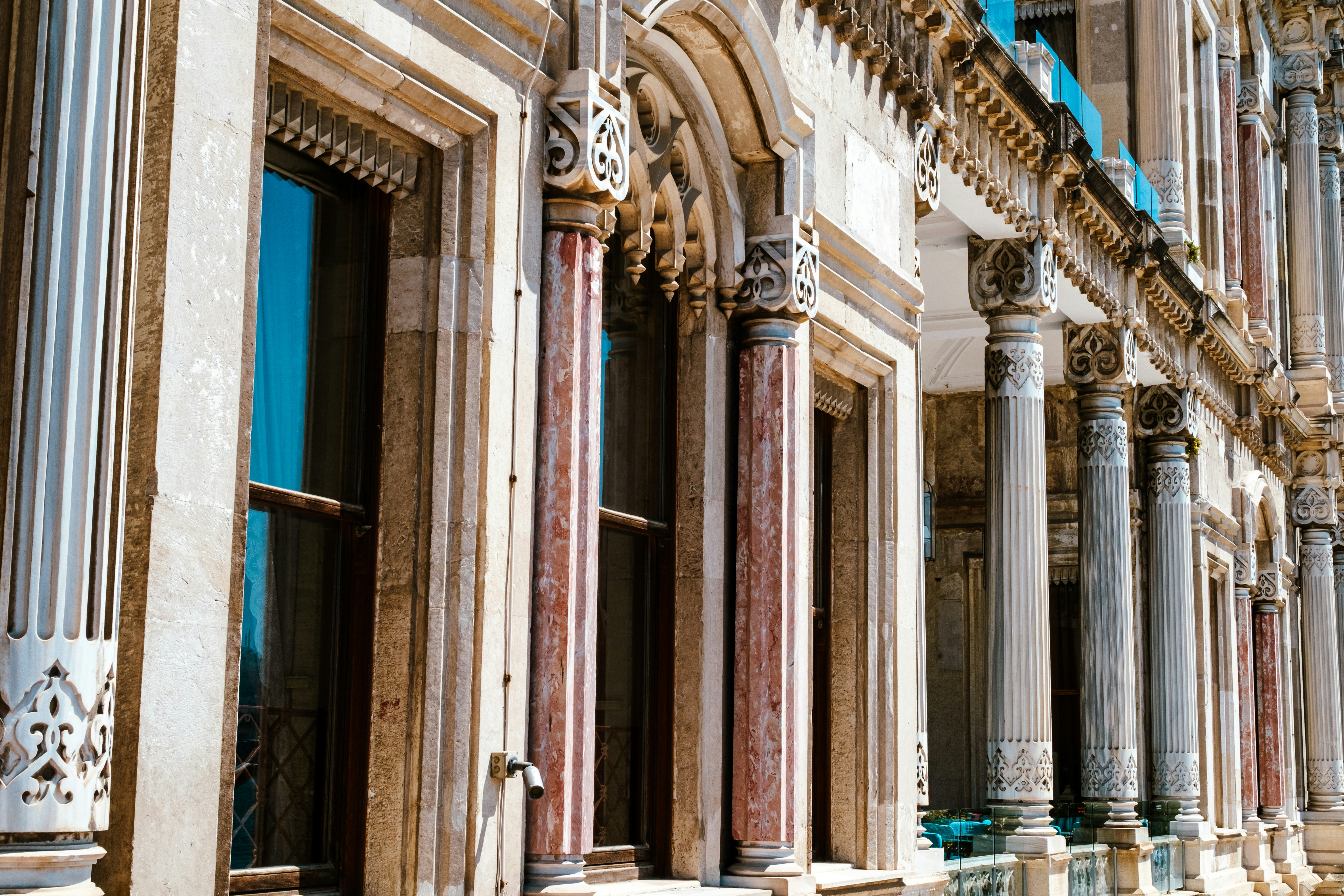 Ornate Marble Arches: Columns and Carvings in Sunlit Facade