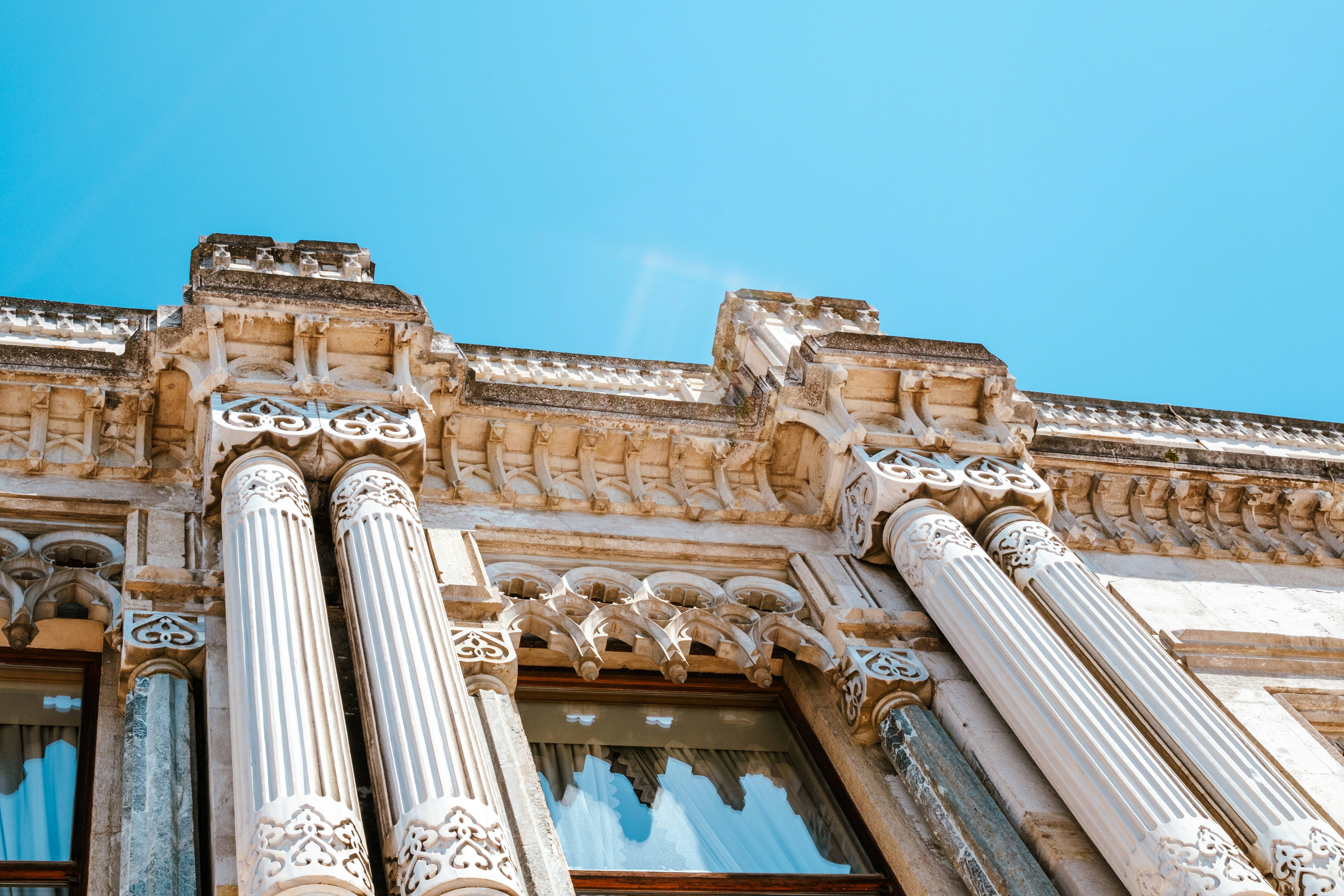 Ornate Classical Facade: Columns and Carved Stonework Framing a Bright Sky