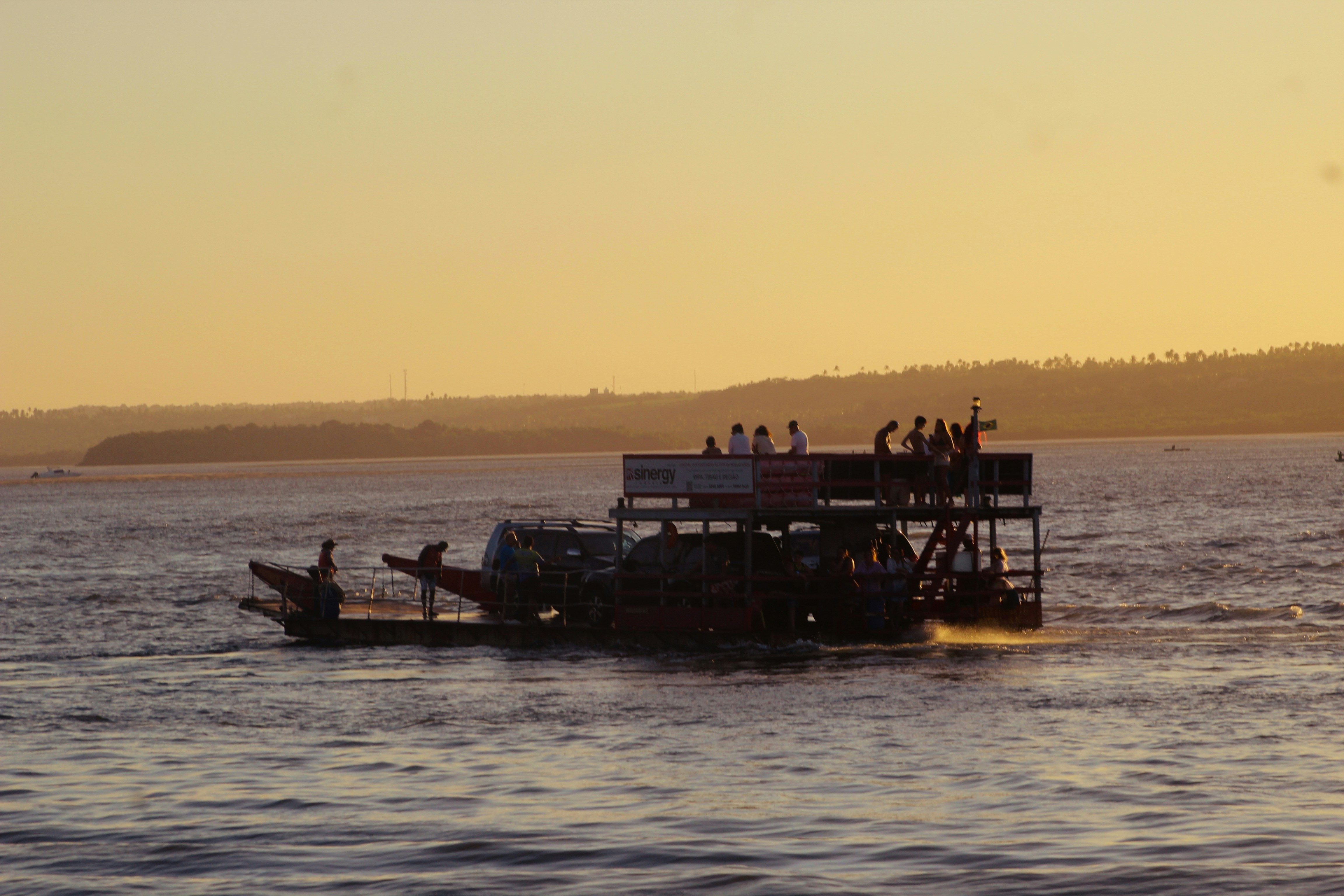 Sunlit Pontoon with Silhouetted Passengers on a Quiet River