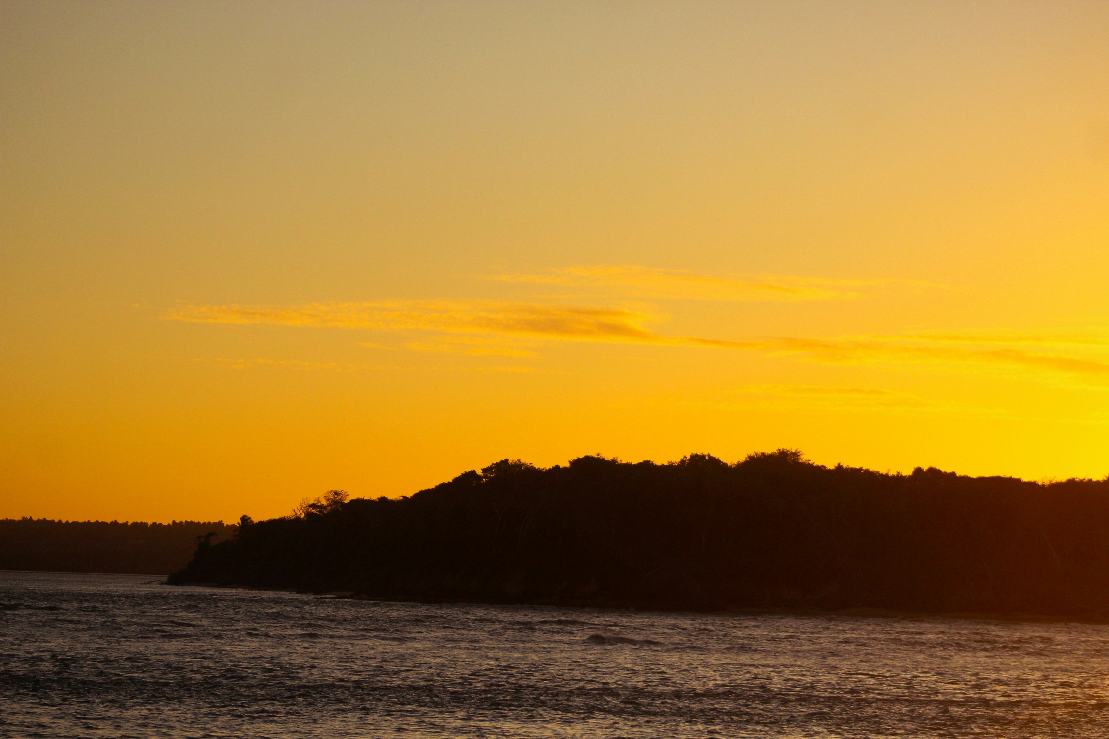 Golden Horizon: Sunset Silhouette Over Calm Waters
