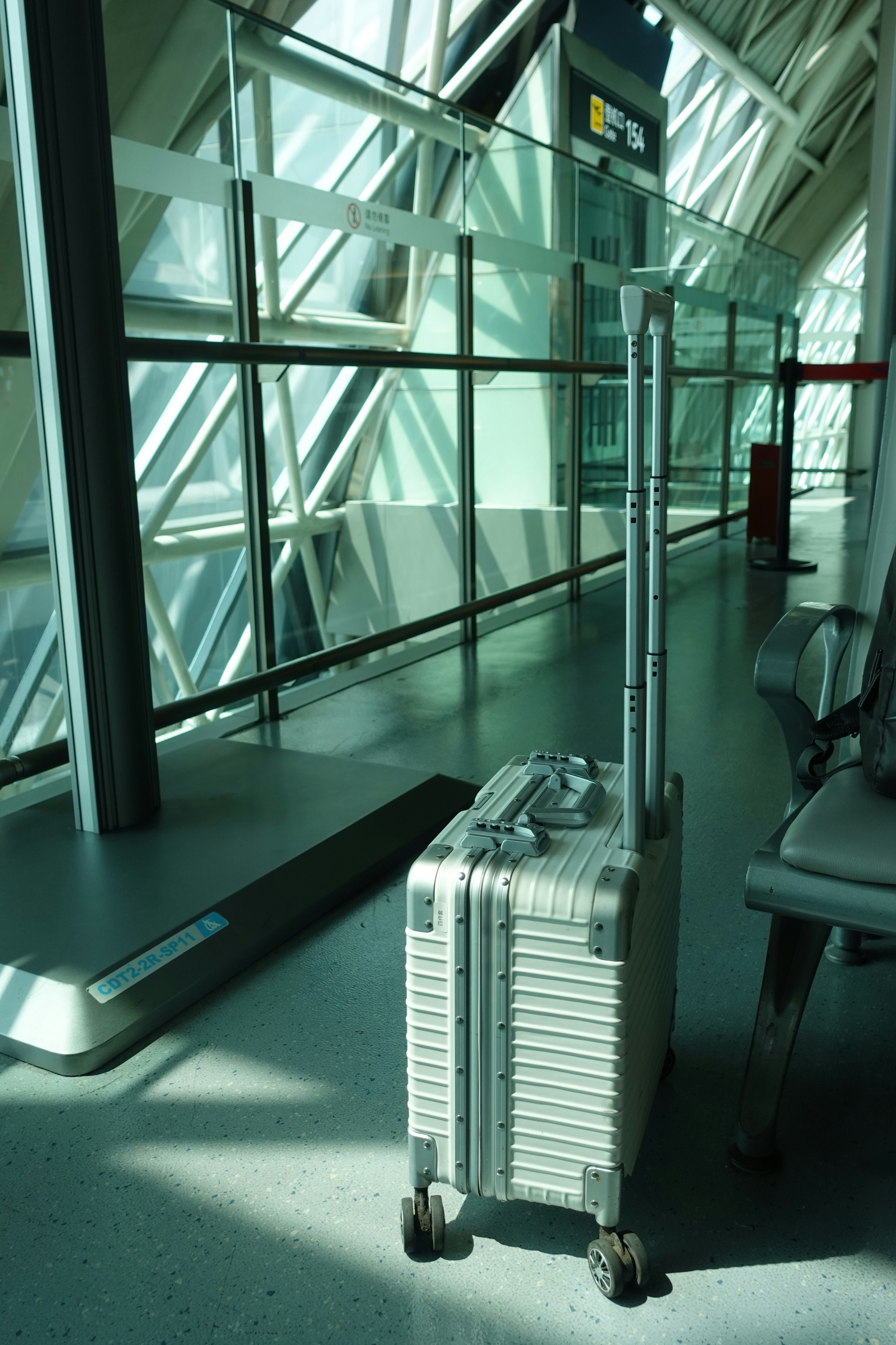 Lone Luggage at the Gate: Silver Carry-On in an Ultra-modern Concourse