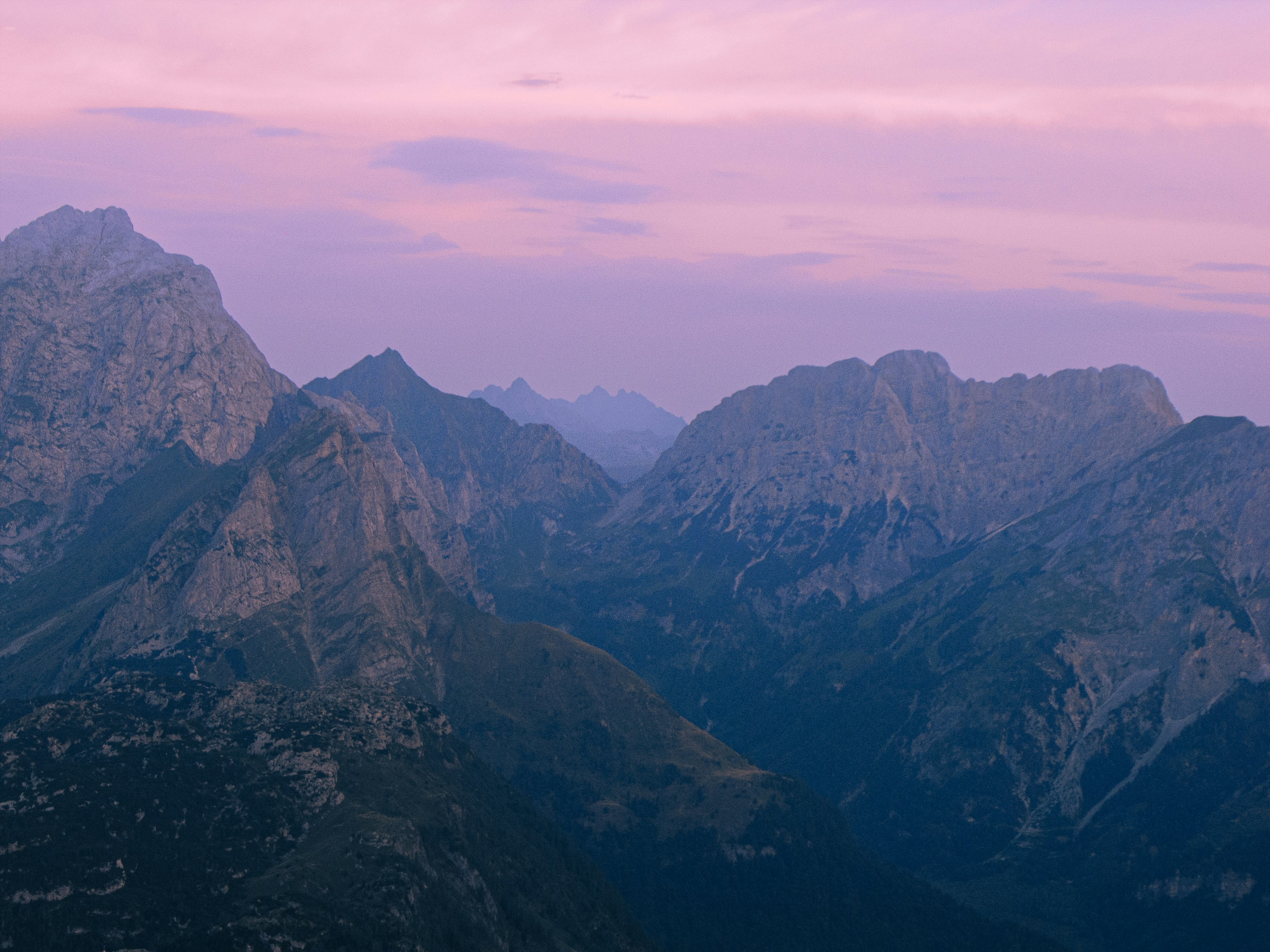 Majestic mountain peaks under a vibrant purple sunset sky.
